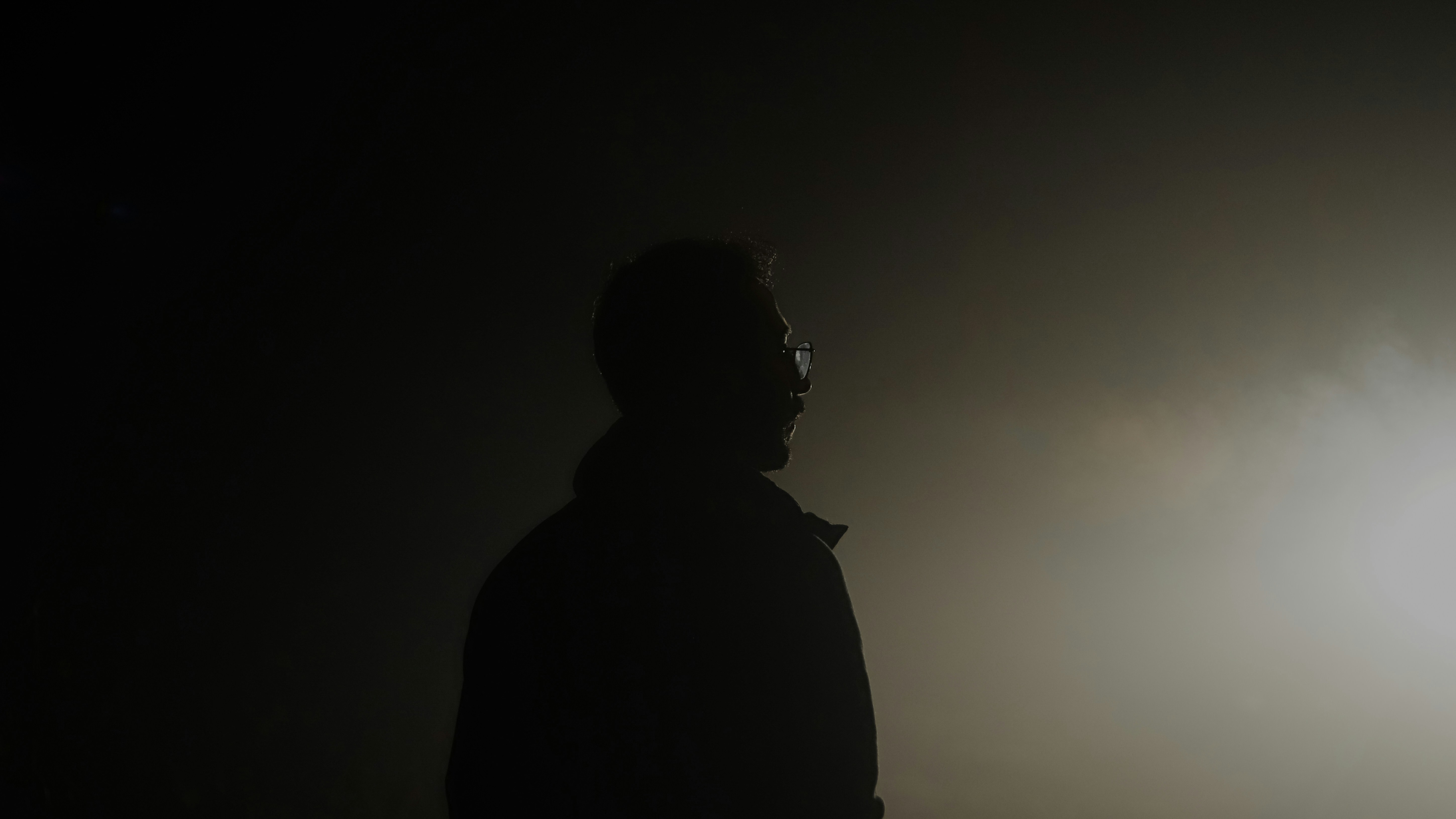 A man standing in the dark with a light shining on him photo – Free Man ...