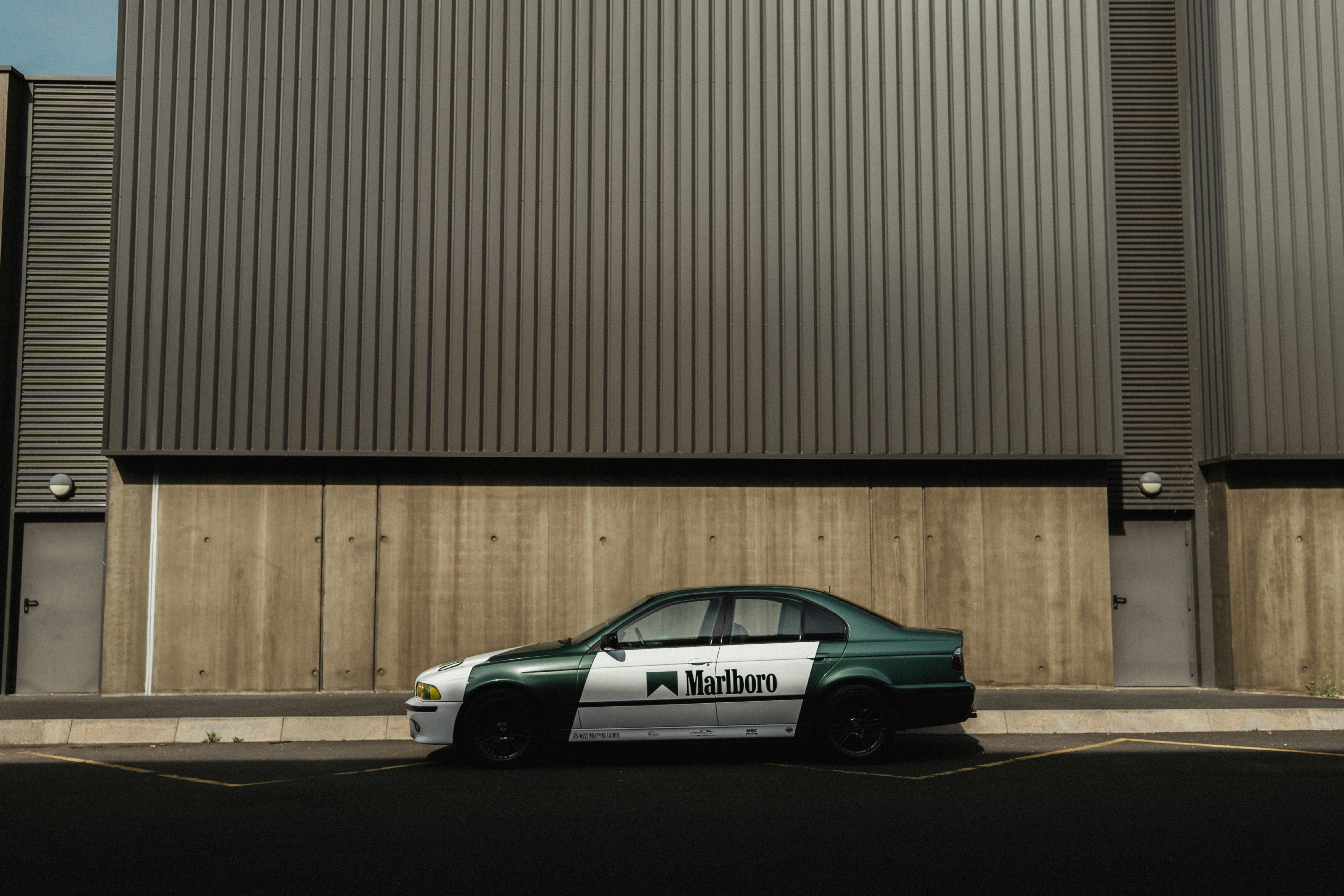 A small green car parked in front of a building photo – Free Car Image ...