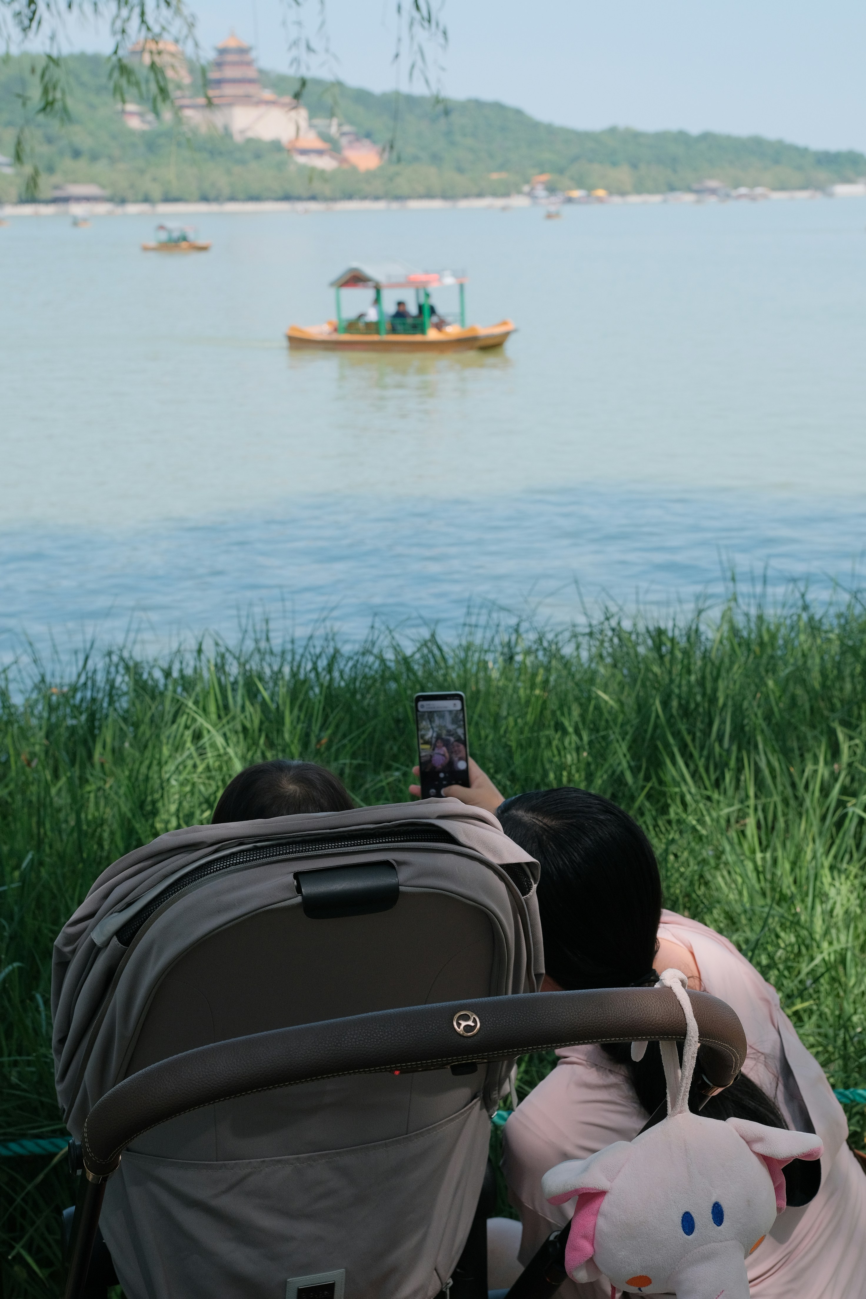 Riverside Moment: A Tiny Boat Gliding Toward a Distant Temple