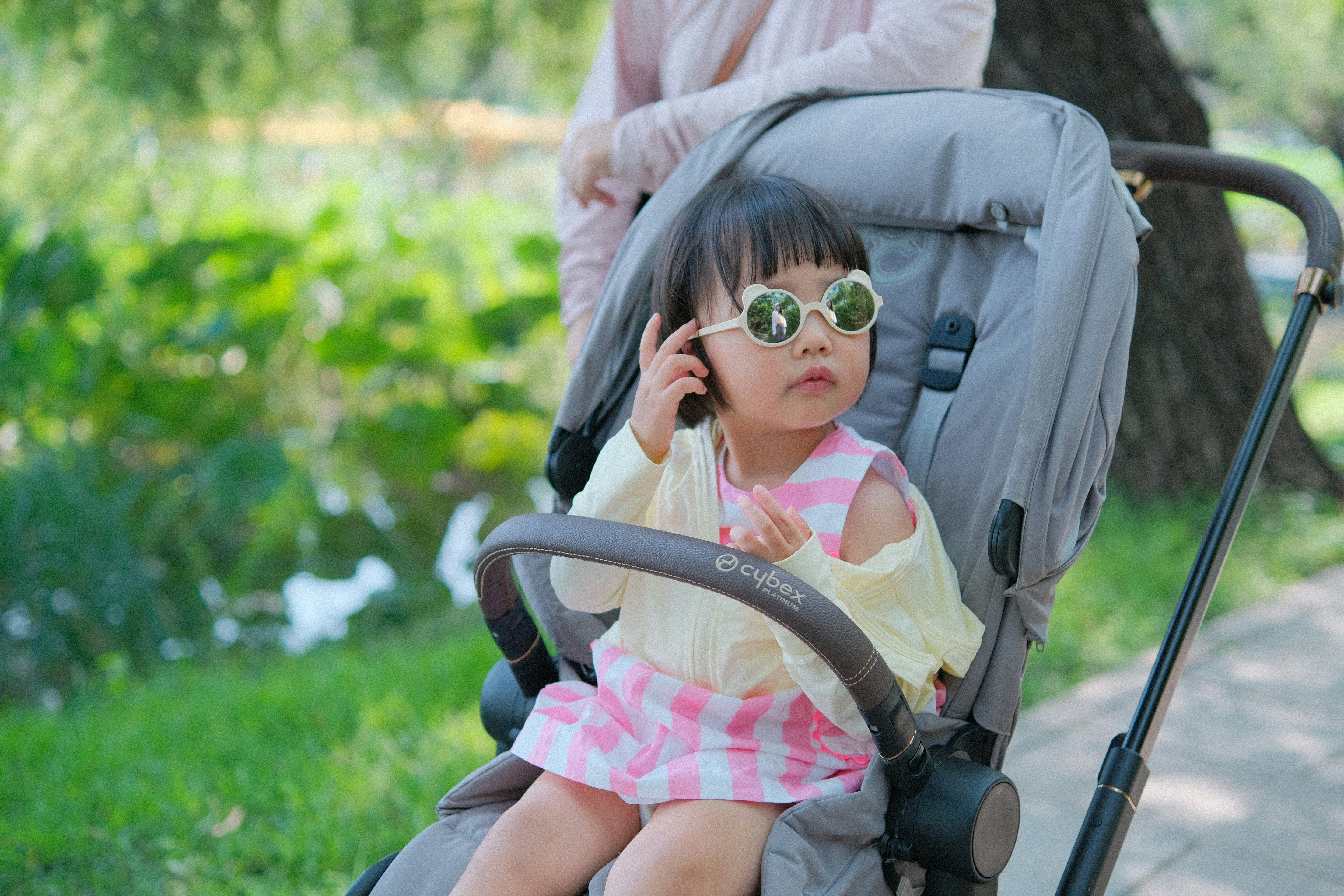 A little girl sitting in a stroller talking on a cell phone photo ...