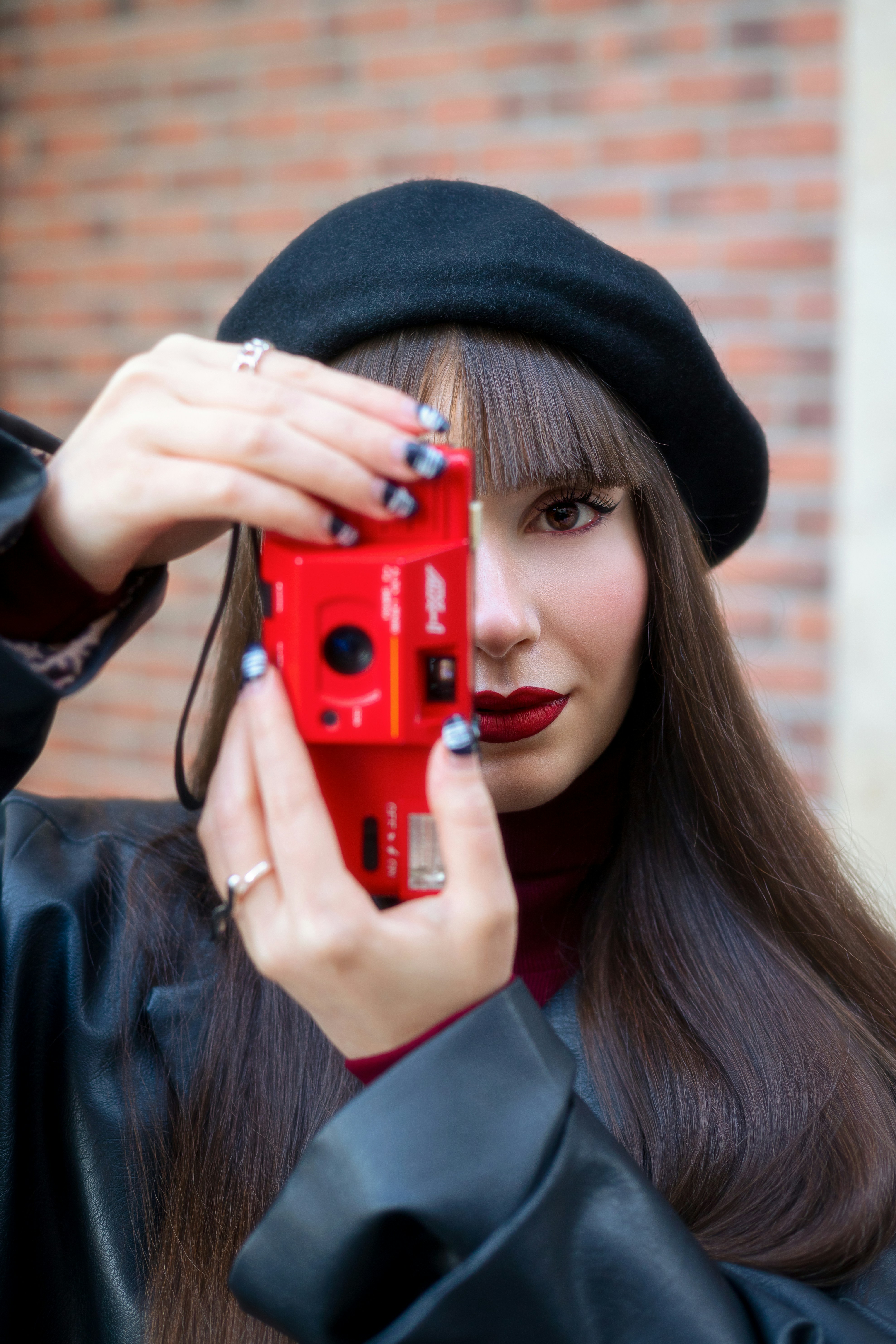 A woman taking a picture of herself with a red camera photo – Free ...