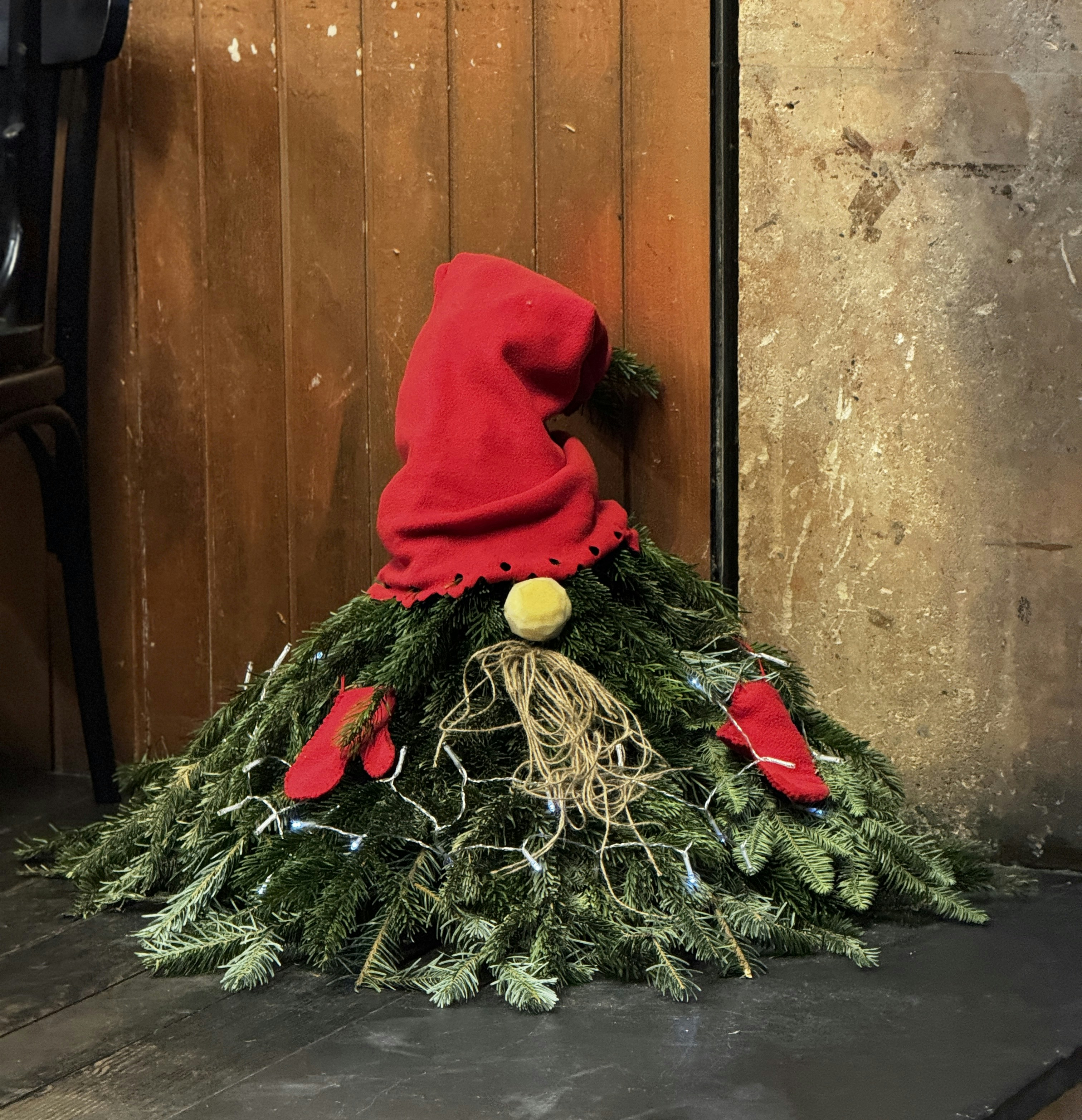 Red-Capped Yuletide Gnome Beneath the Rustic Stair