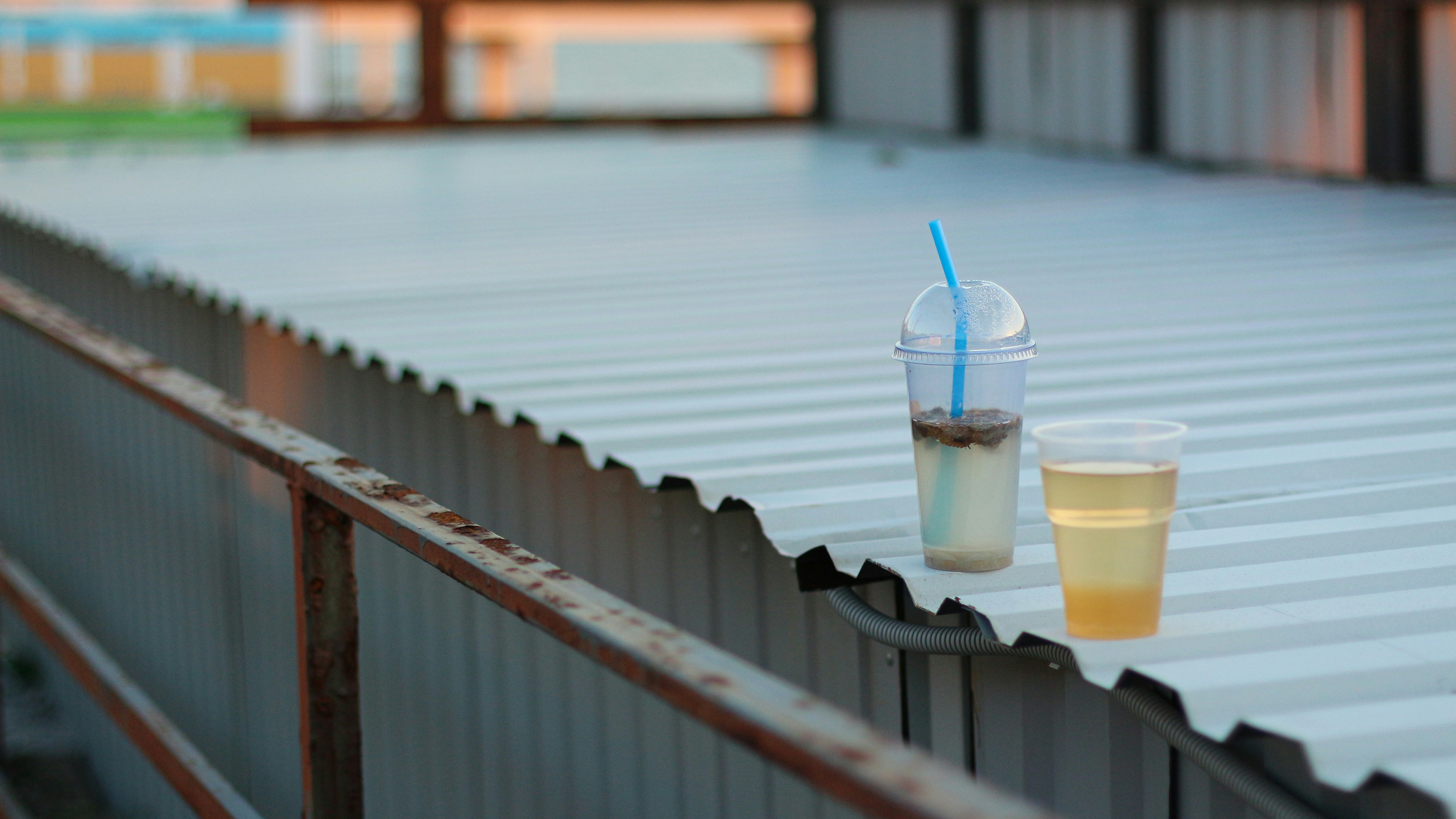 Edge of the Roof: A pair of drinks perched on weathered corrugated metal