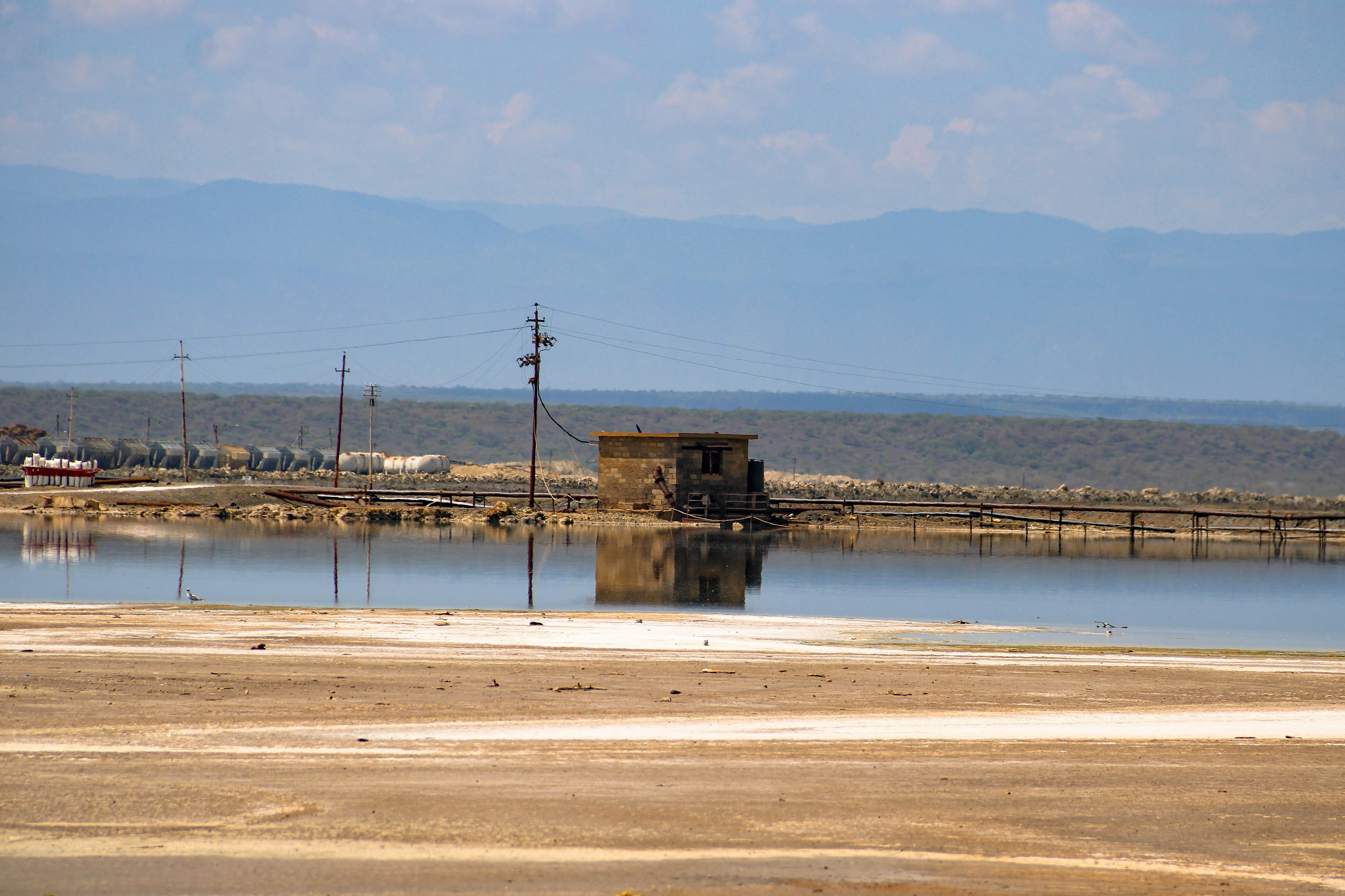 A large body of water sitting under a blue sky photo – Free Kenya Image ...