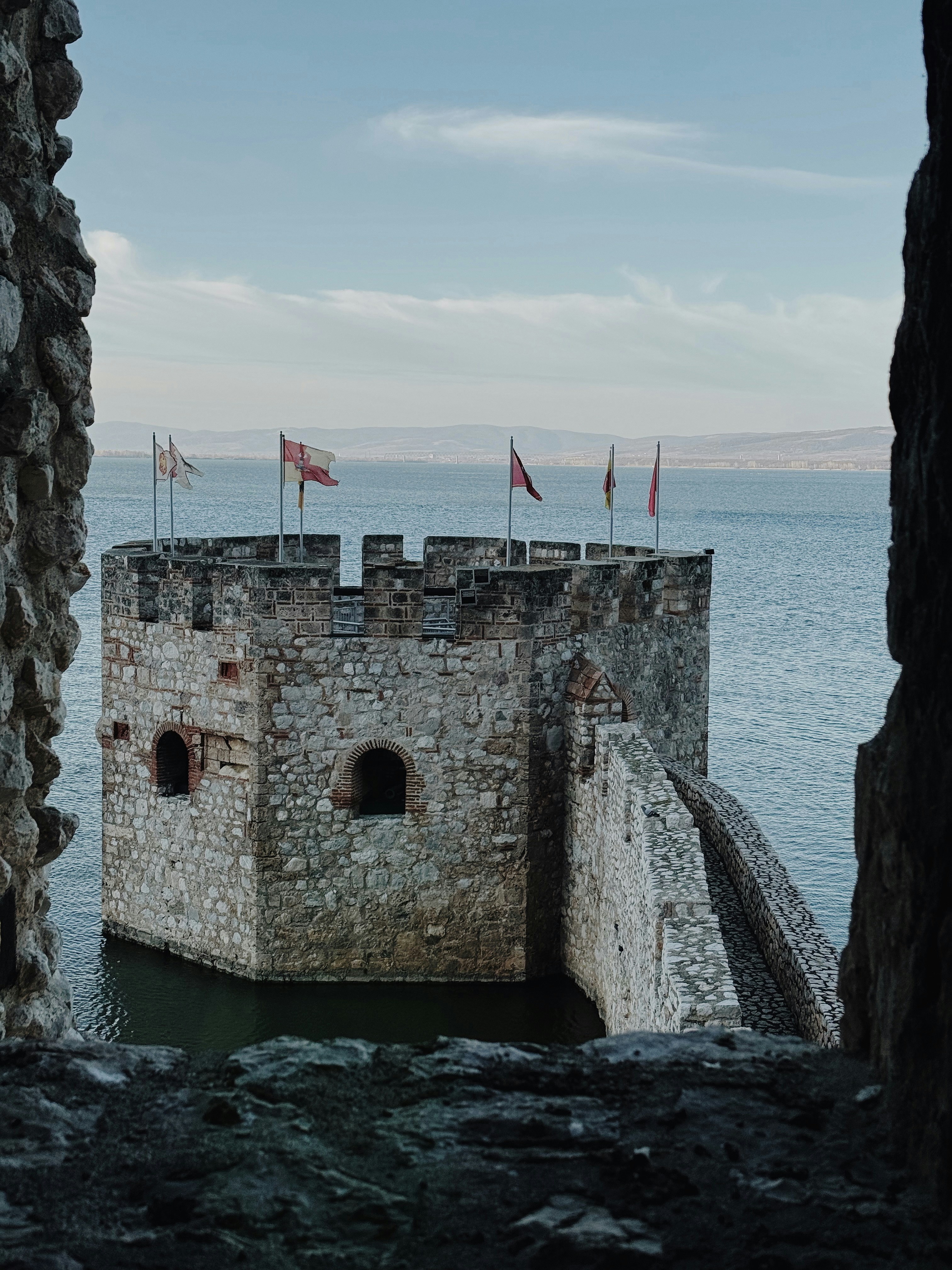 Seabound Citadel: The Stone Fortress Framed by Rustic Cavern Walls