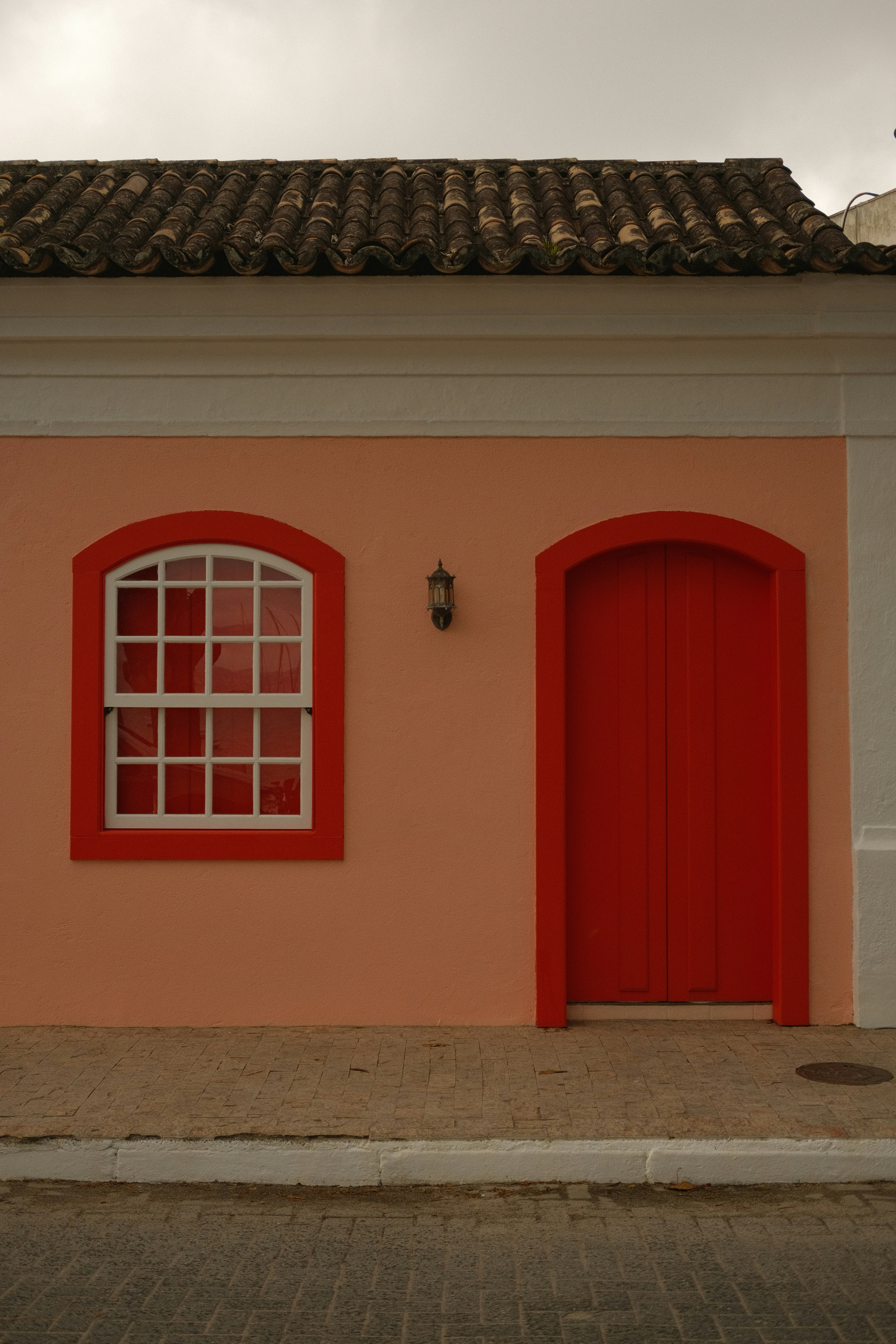 Crimson Doorway on a Peach Facade: A Quiet Architectural Moment