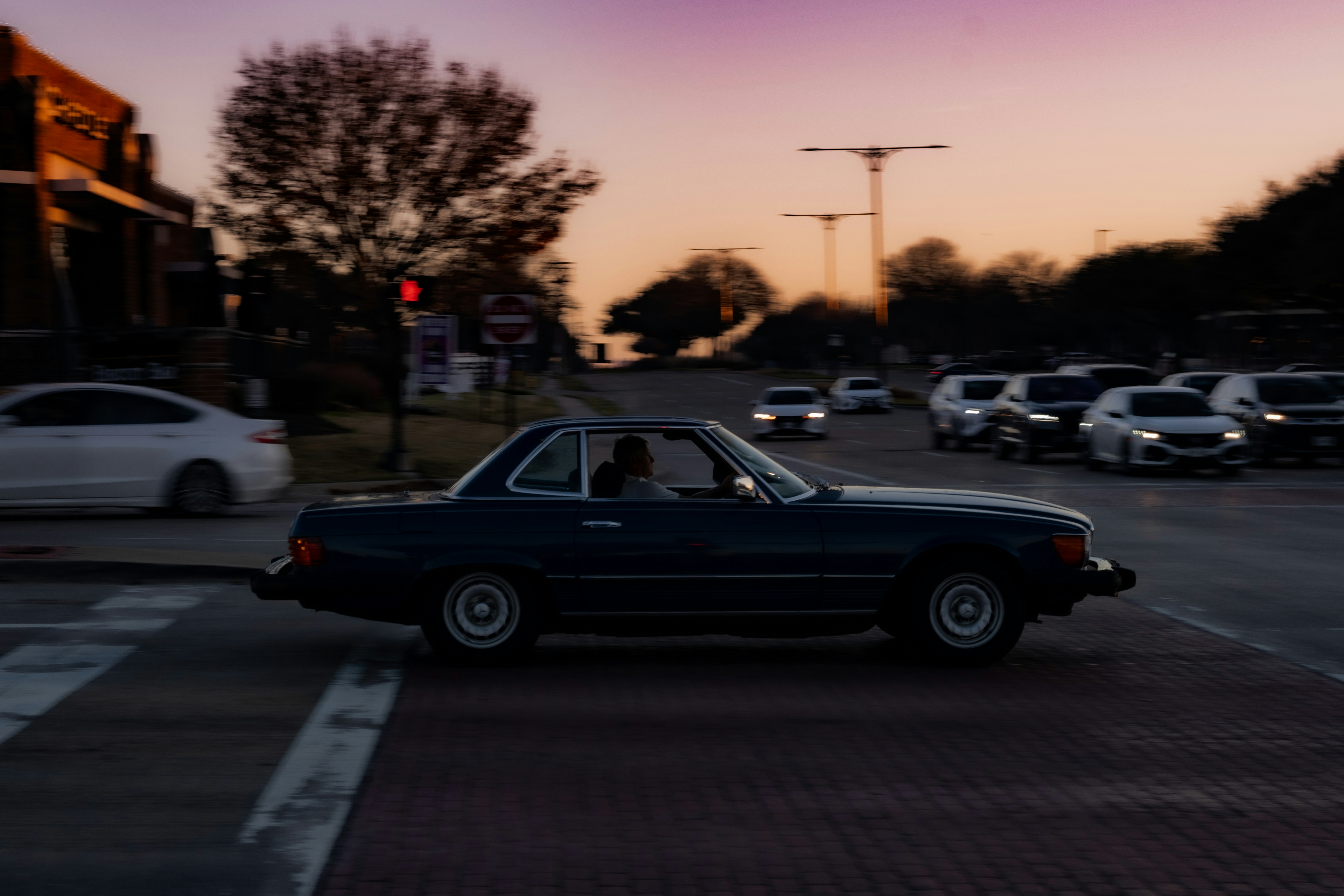 Dusk Crossing: Blue Vintage Sedan in Motion