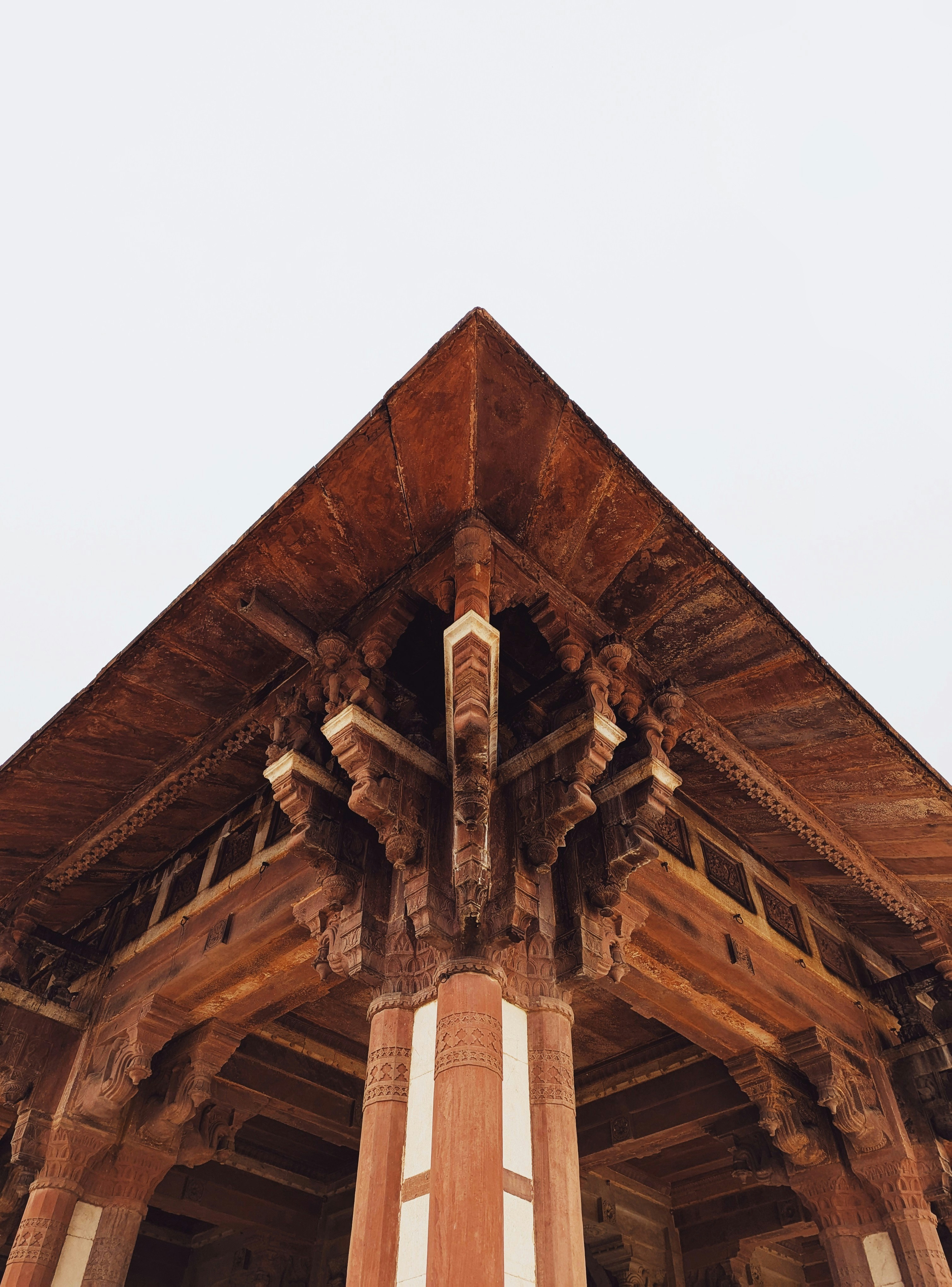 Corner Crown of Carved Timber: Intricate Temple Brackets Under a Sloping Roof