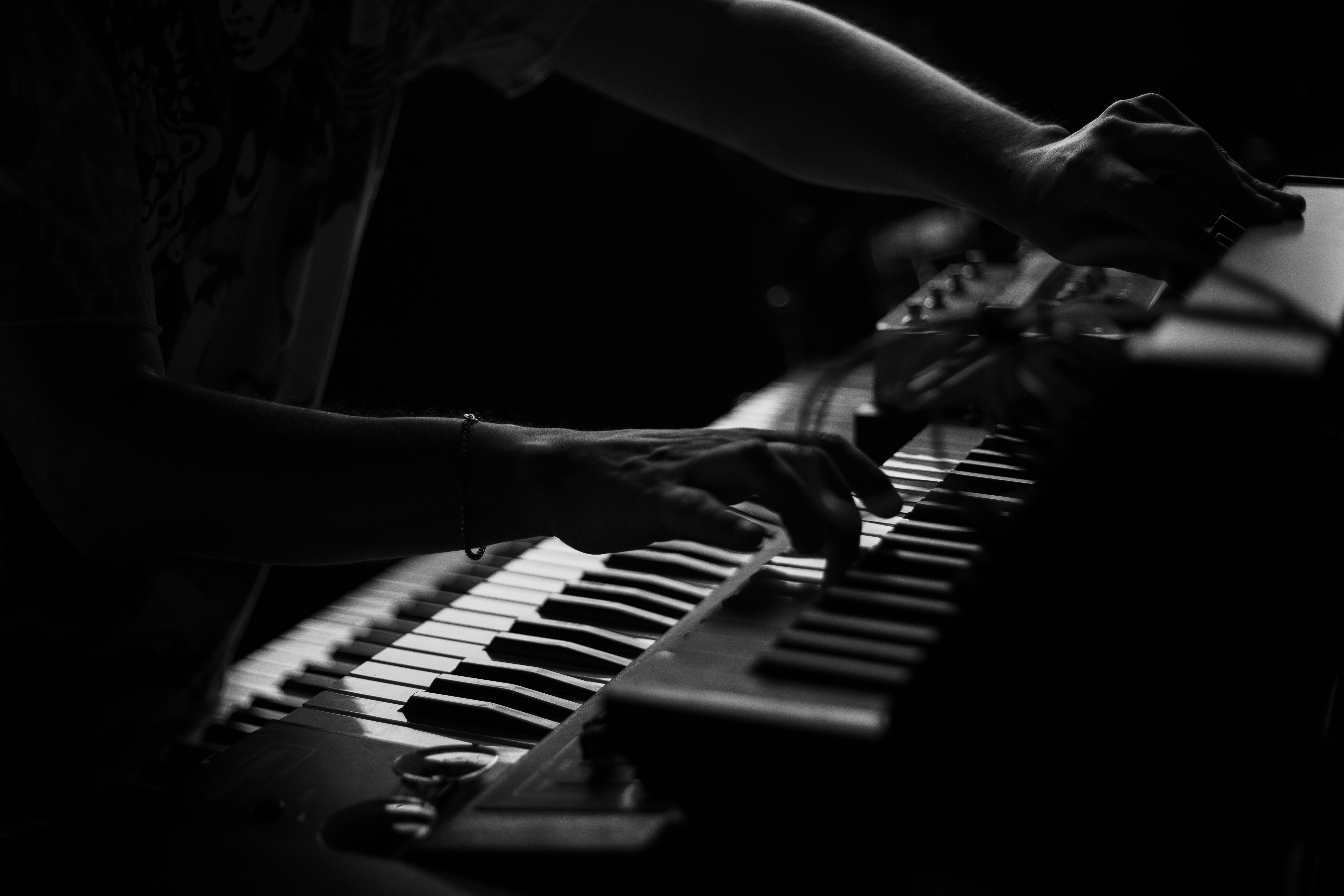 A person playing a keyboard in a dark room photo – Free Man Image on ...