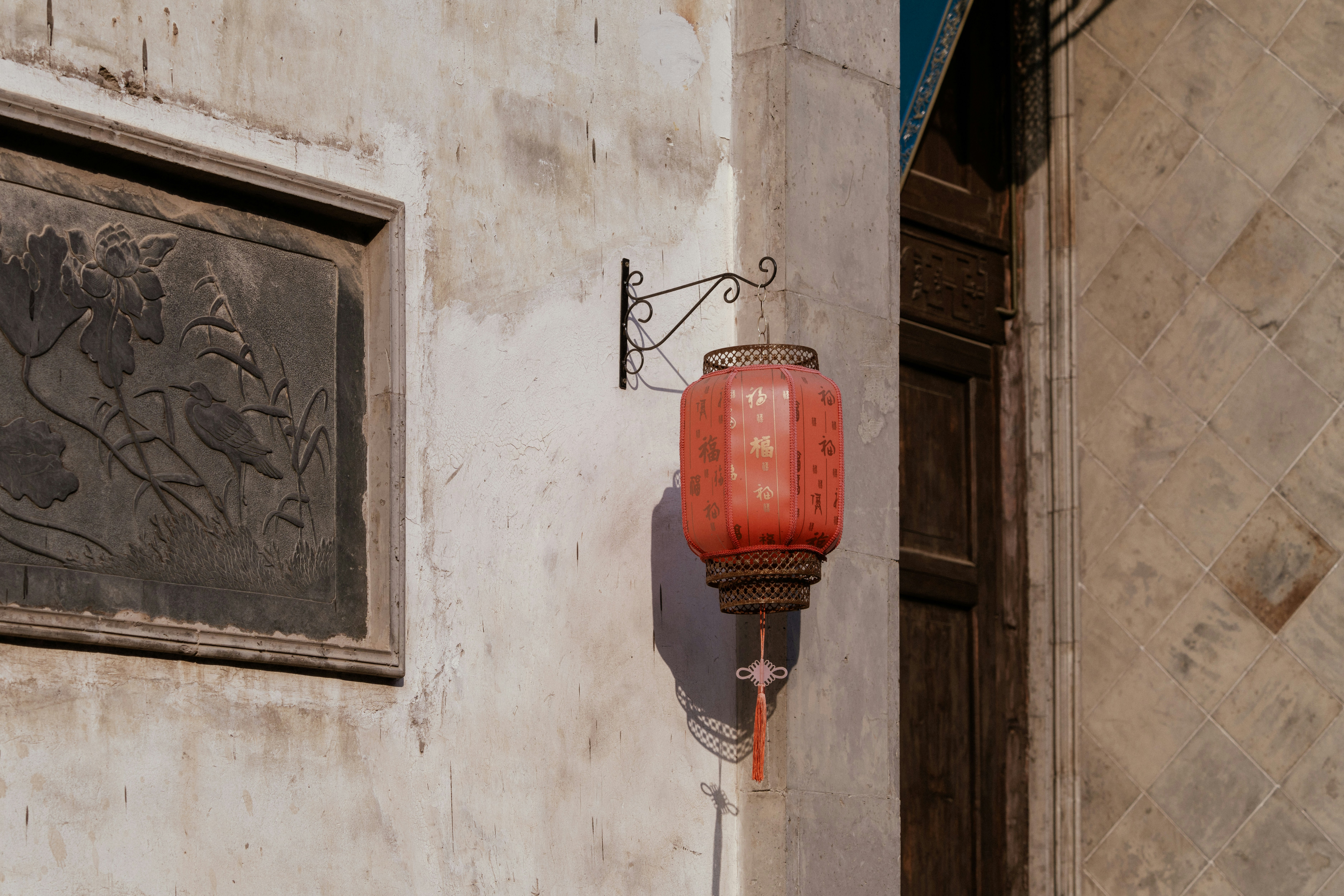 A red lantern hanging on the side of a building