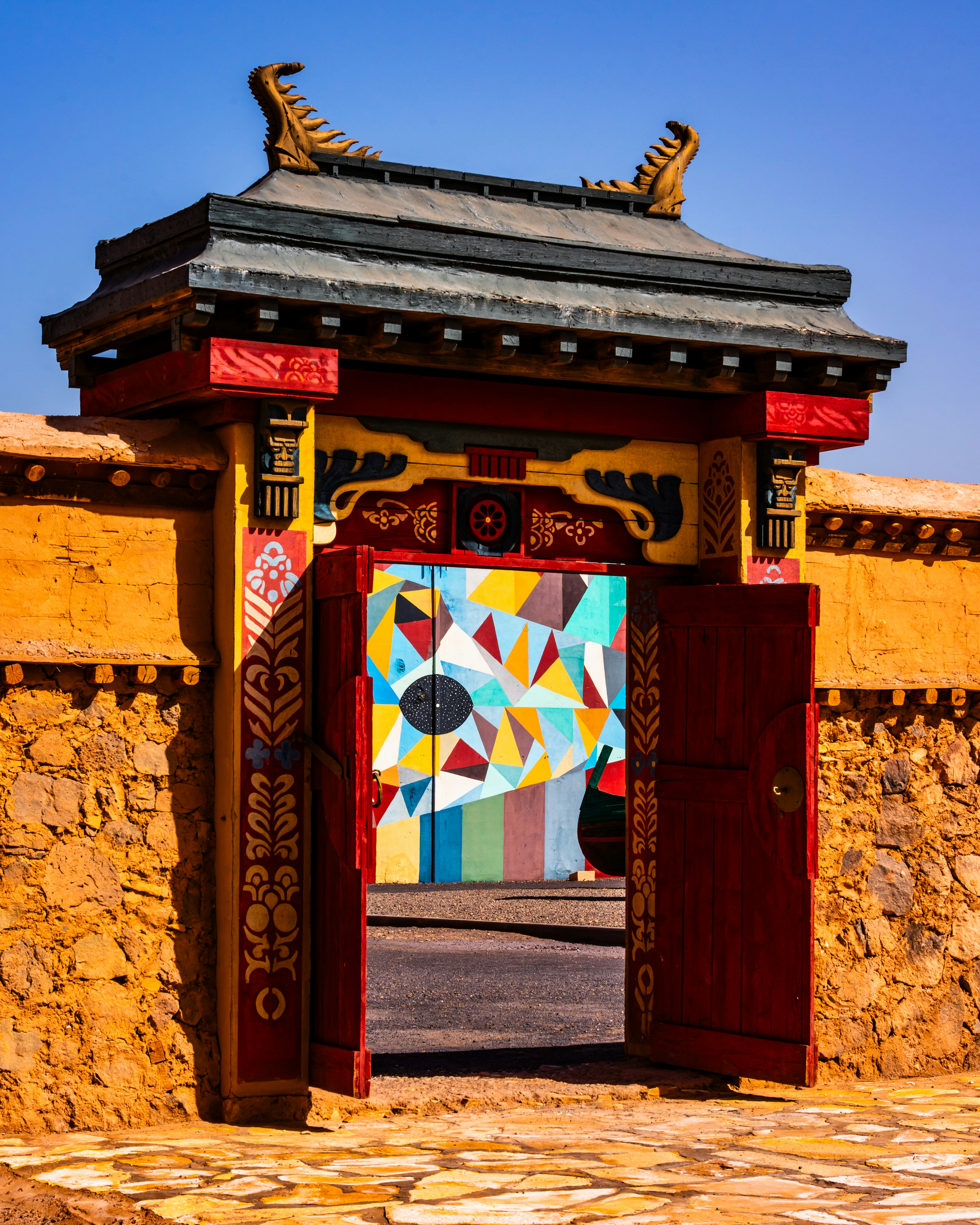 A red and yellow gate with a painting on it photo – Free Atlas studios ...