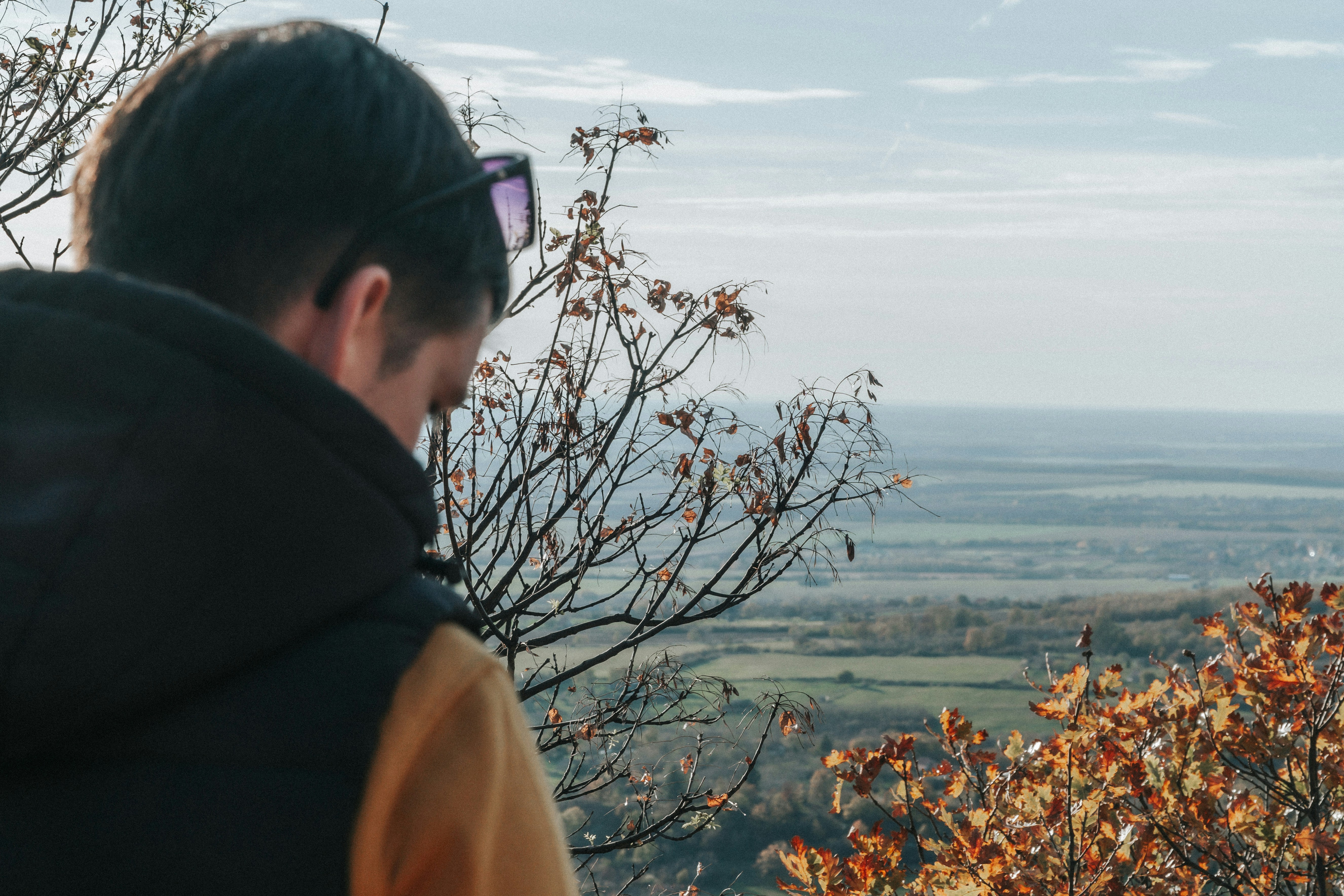 A man standing on top of a hill overlooking a valley photo – Free ...