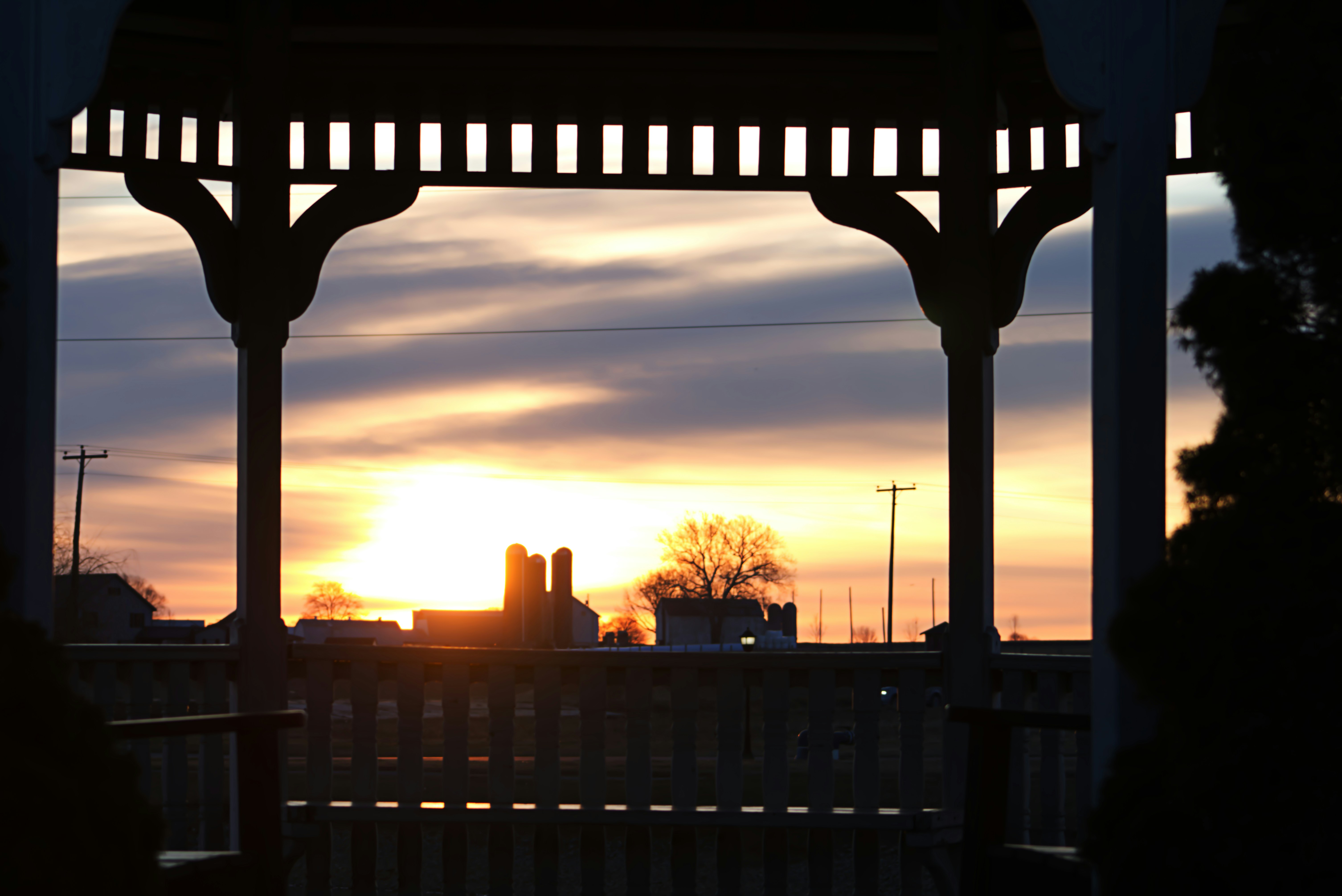 Sunset Lattice: Silhouettes Framed by a Wooden Pavilion