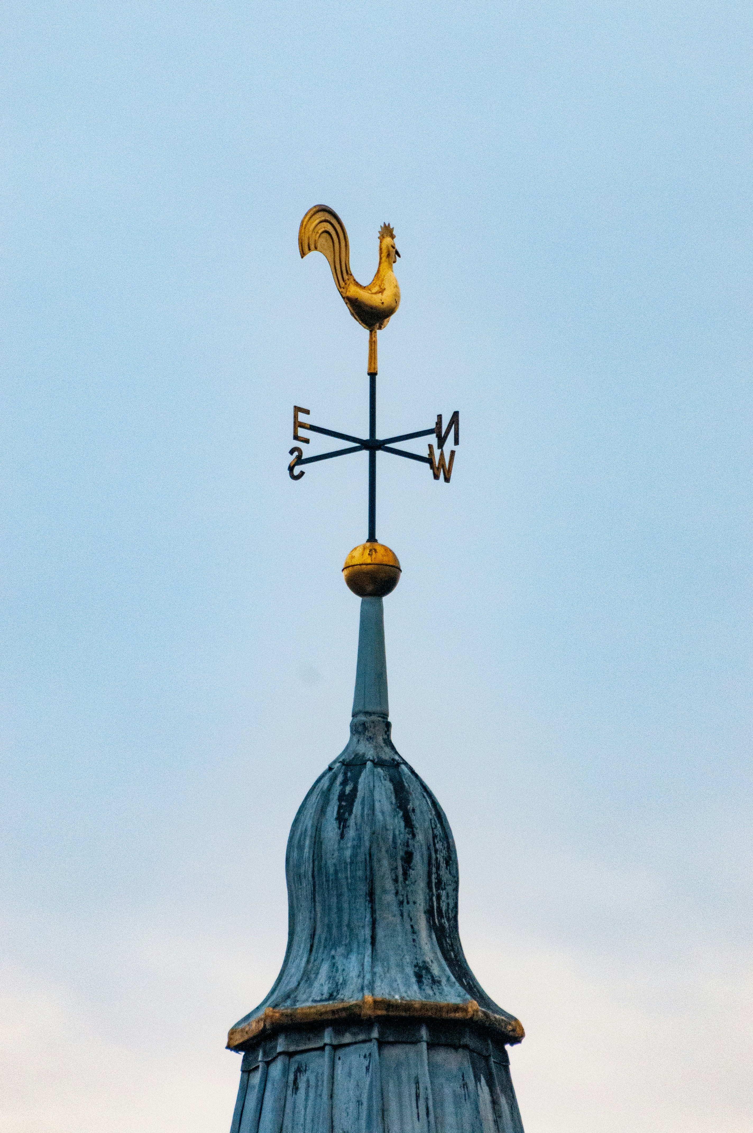 A weather vane on top of a building photo – Free Cross Image on Unsplash
