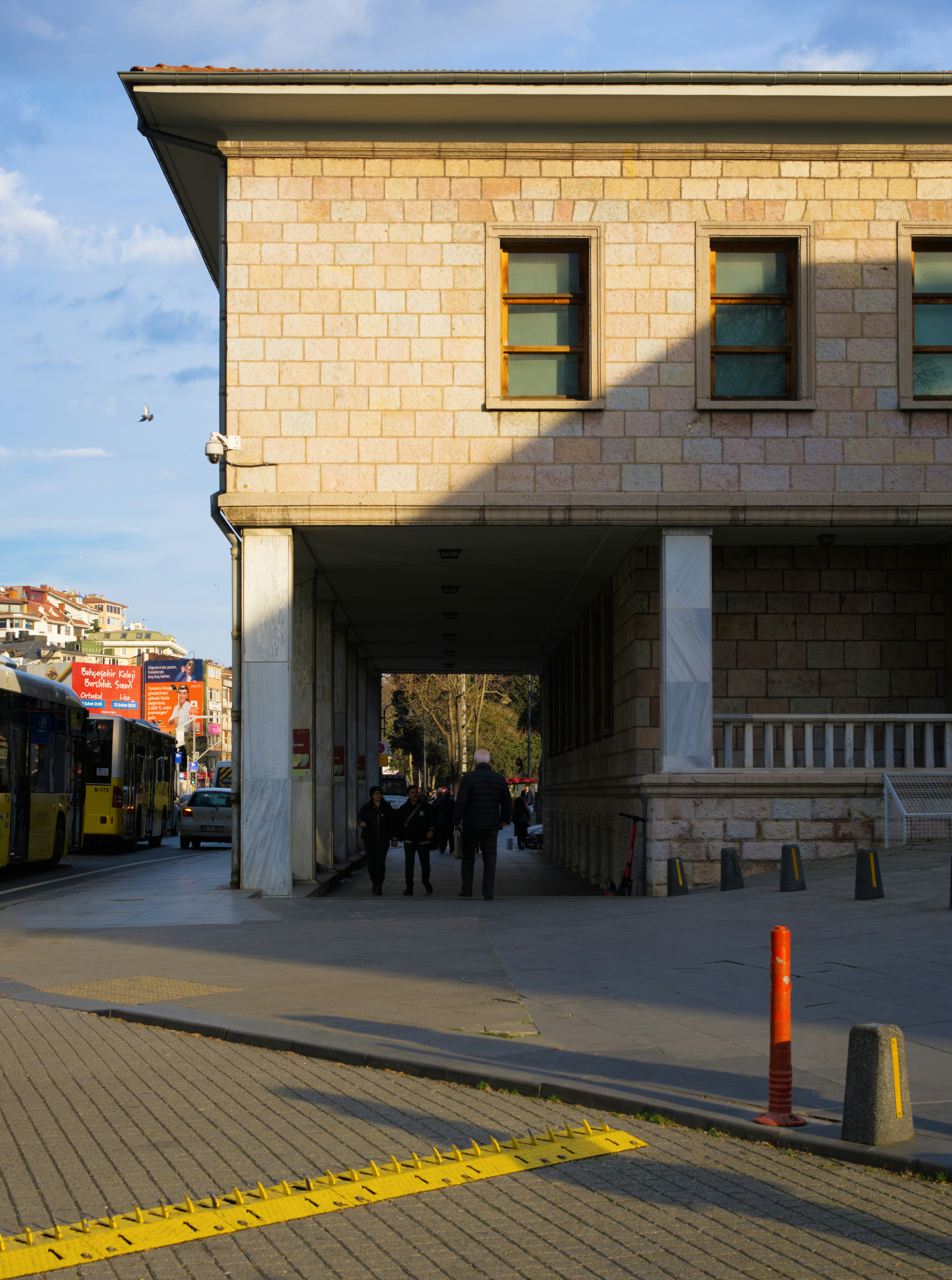Arcade Crossing: Light and Shadow Under a Stone Facade