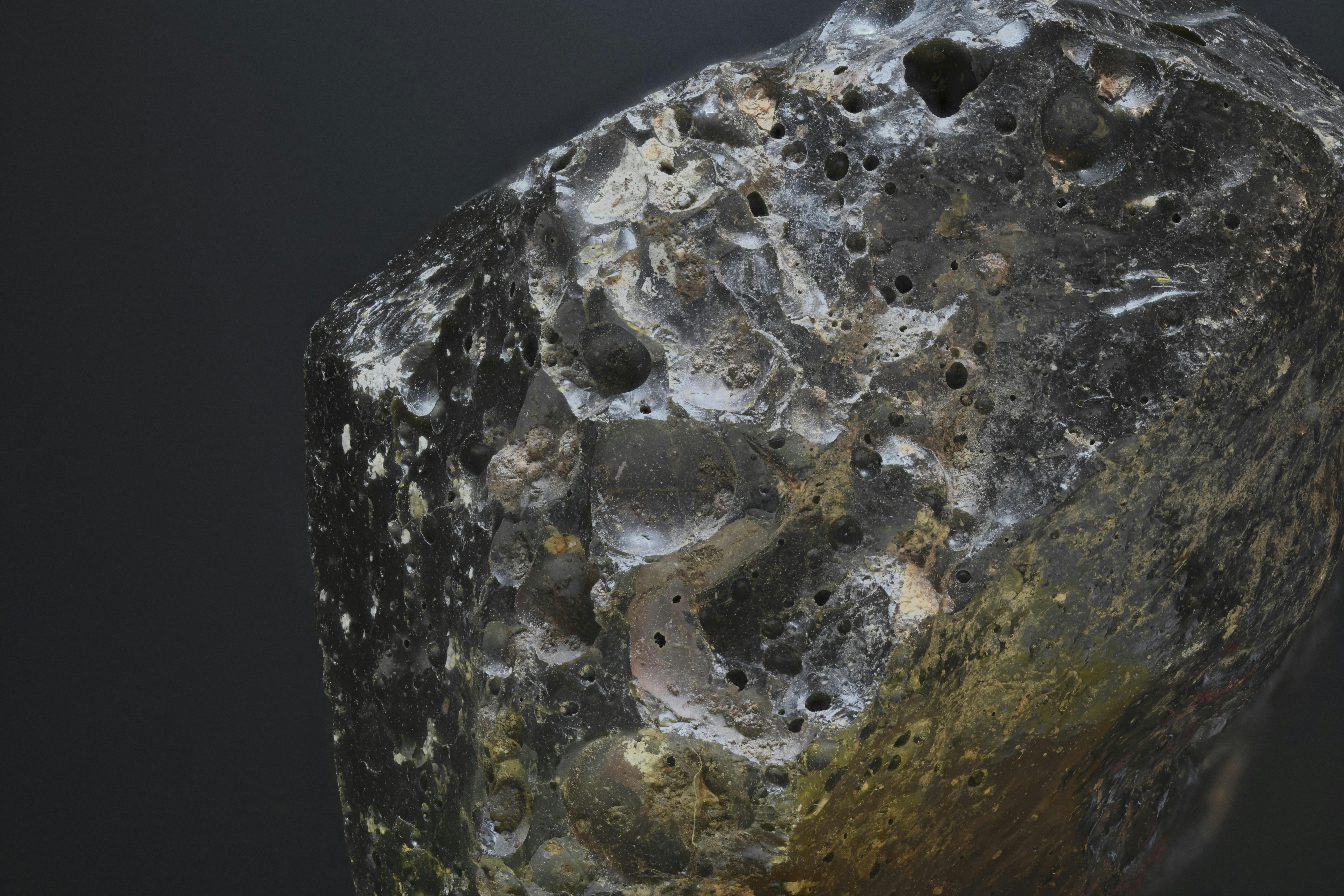 A rock with holes in it on a black background photo – Free Macro Image ...