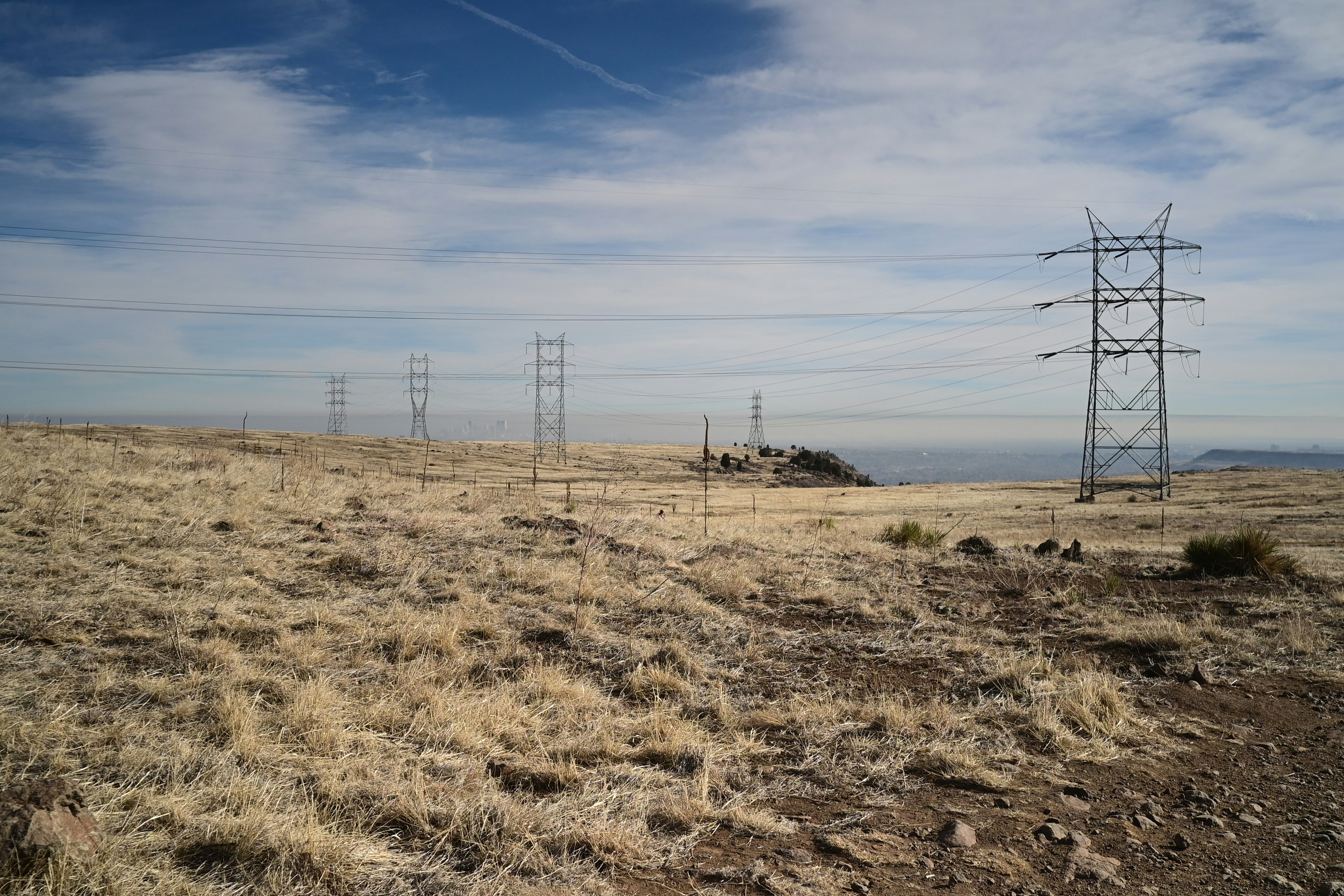 A dirt field with power lines in the distance photo – Free Ground Image ...