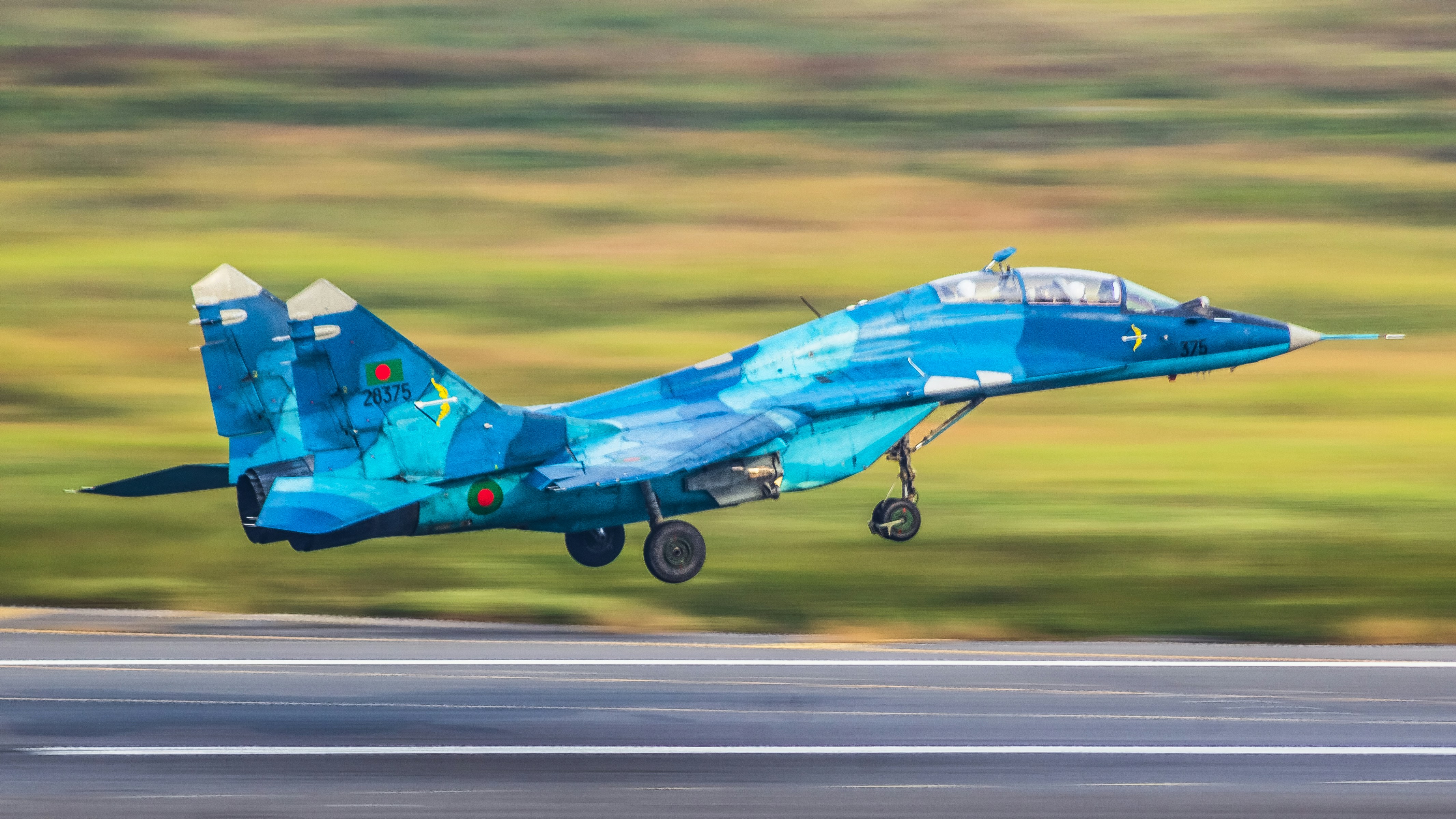 A blue fighter jet taking off from an airport runway photo – Free ...