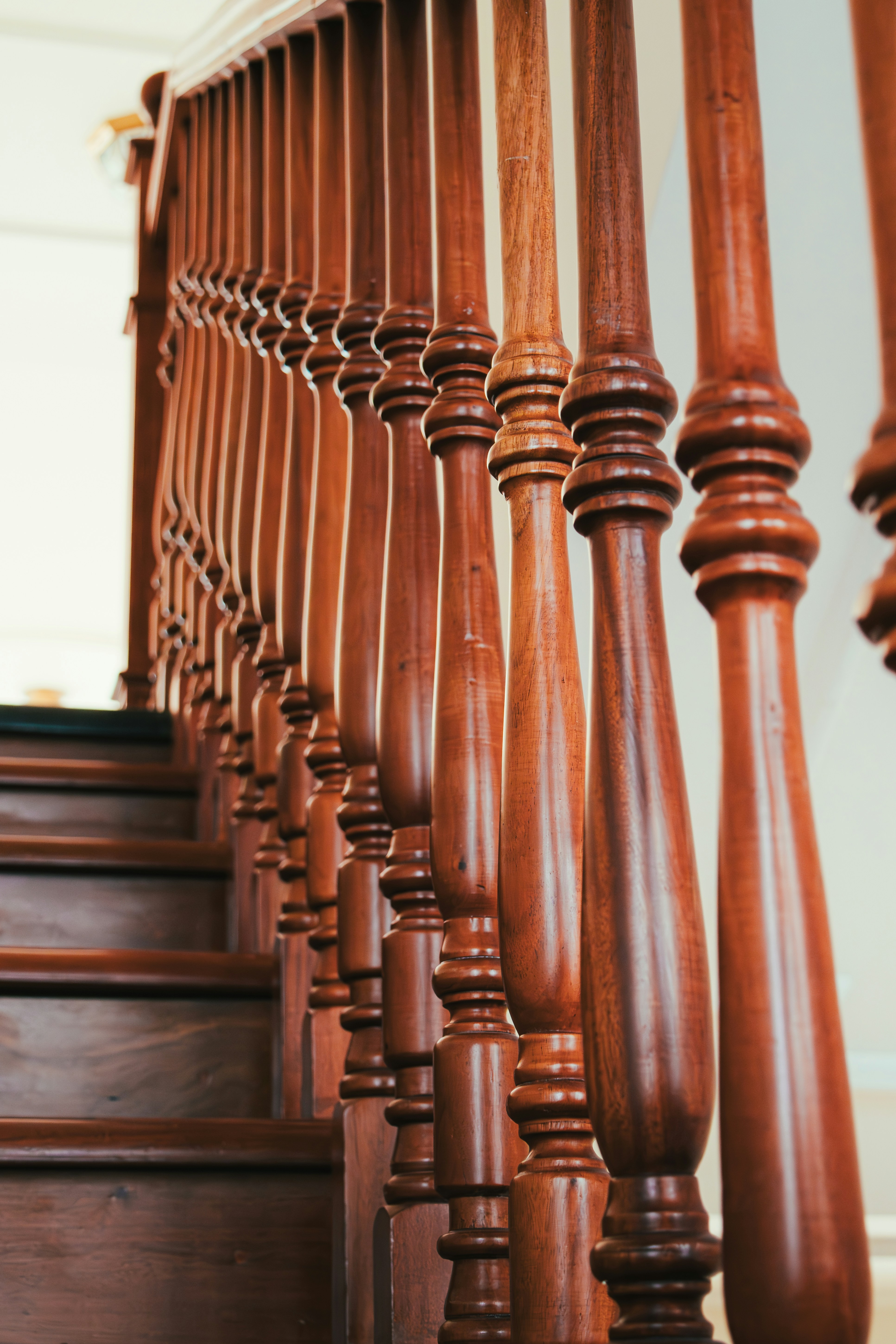 Spindle Symphony: Close-Up of Warm Wooden Balusters Vanishing into the Stair