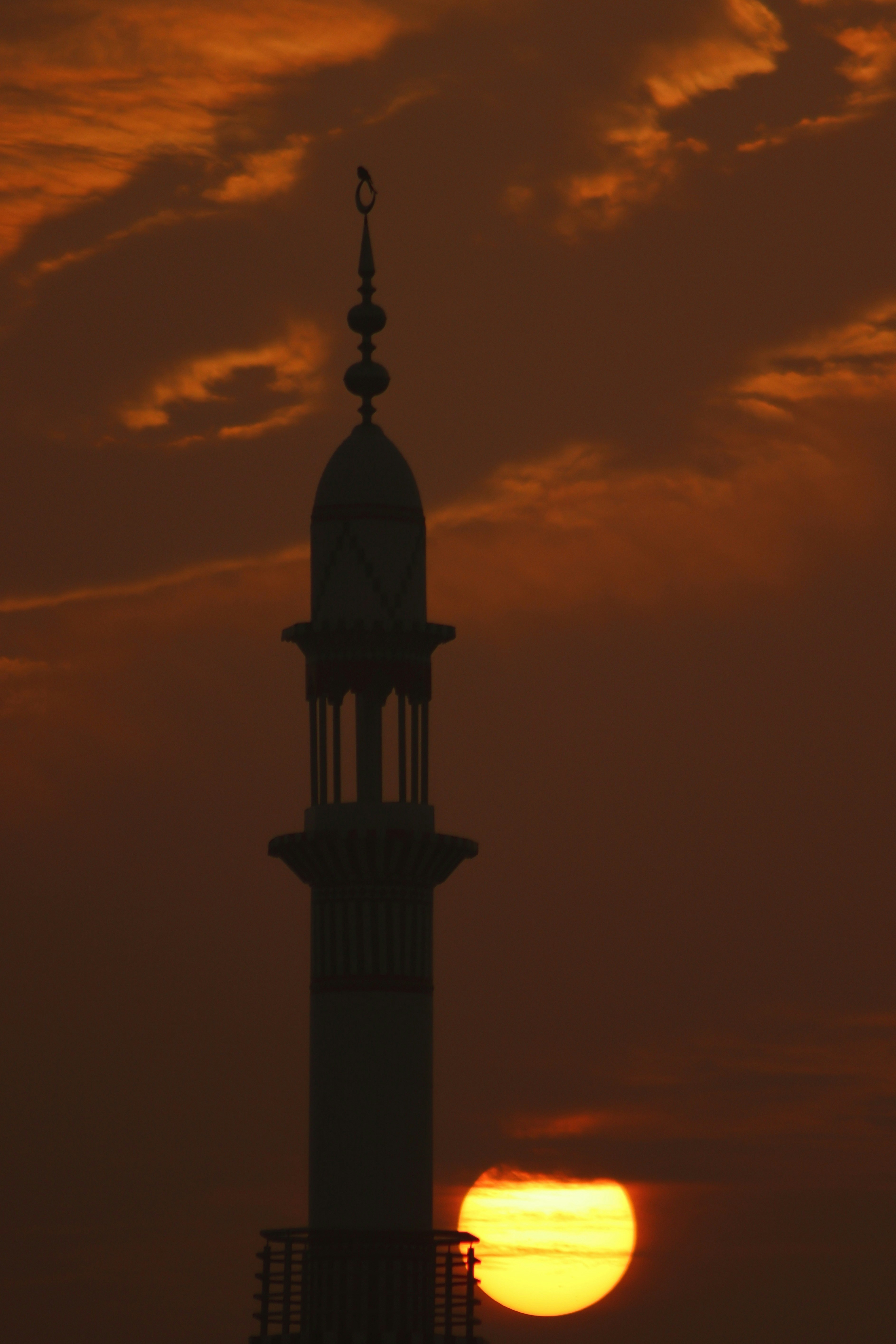 The sun is setting behind a clock tower photo – Free Sunset Image on ...