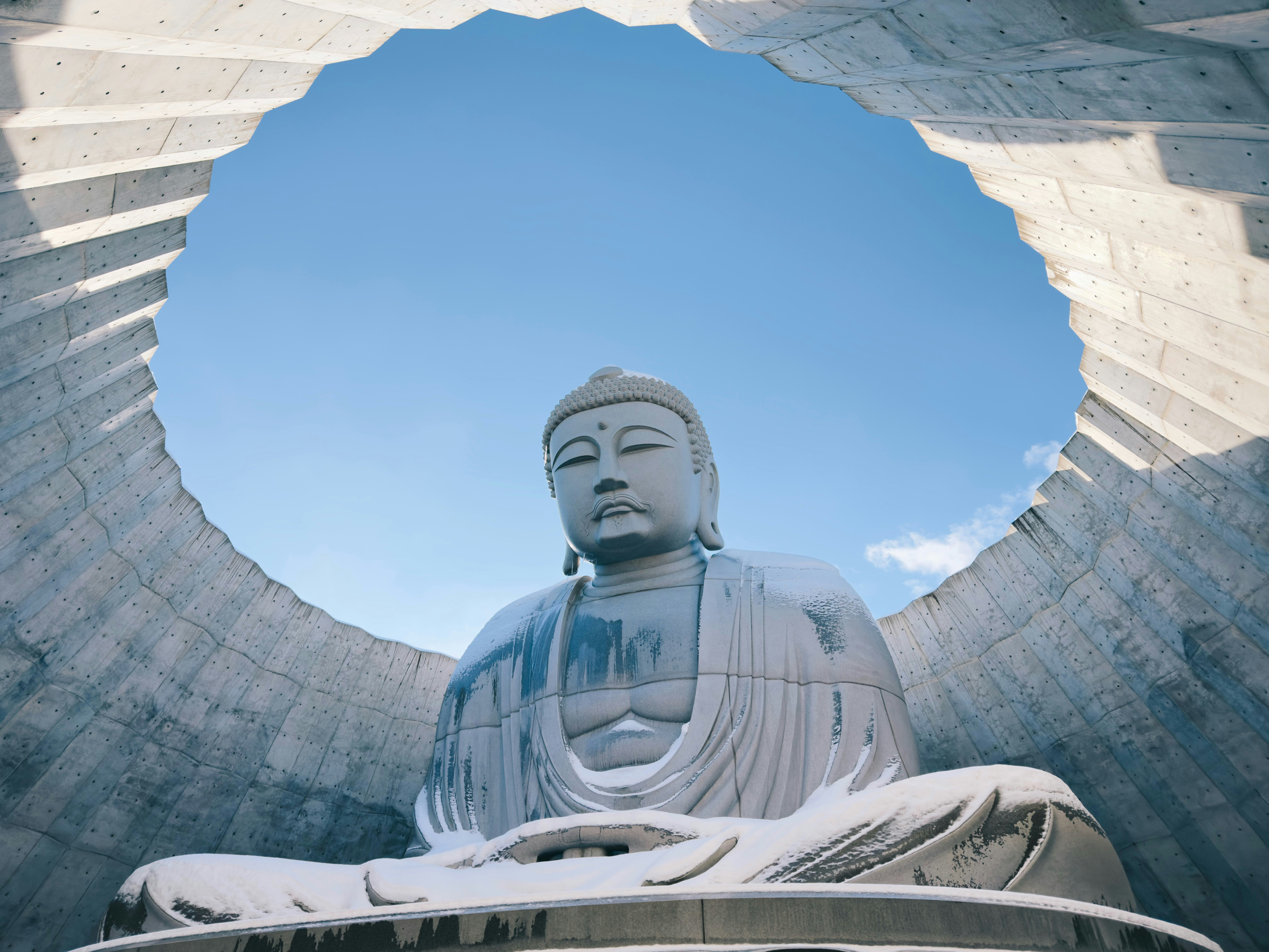 A large buddha statue sitting in front of a blue sky photo – Free ...