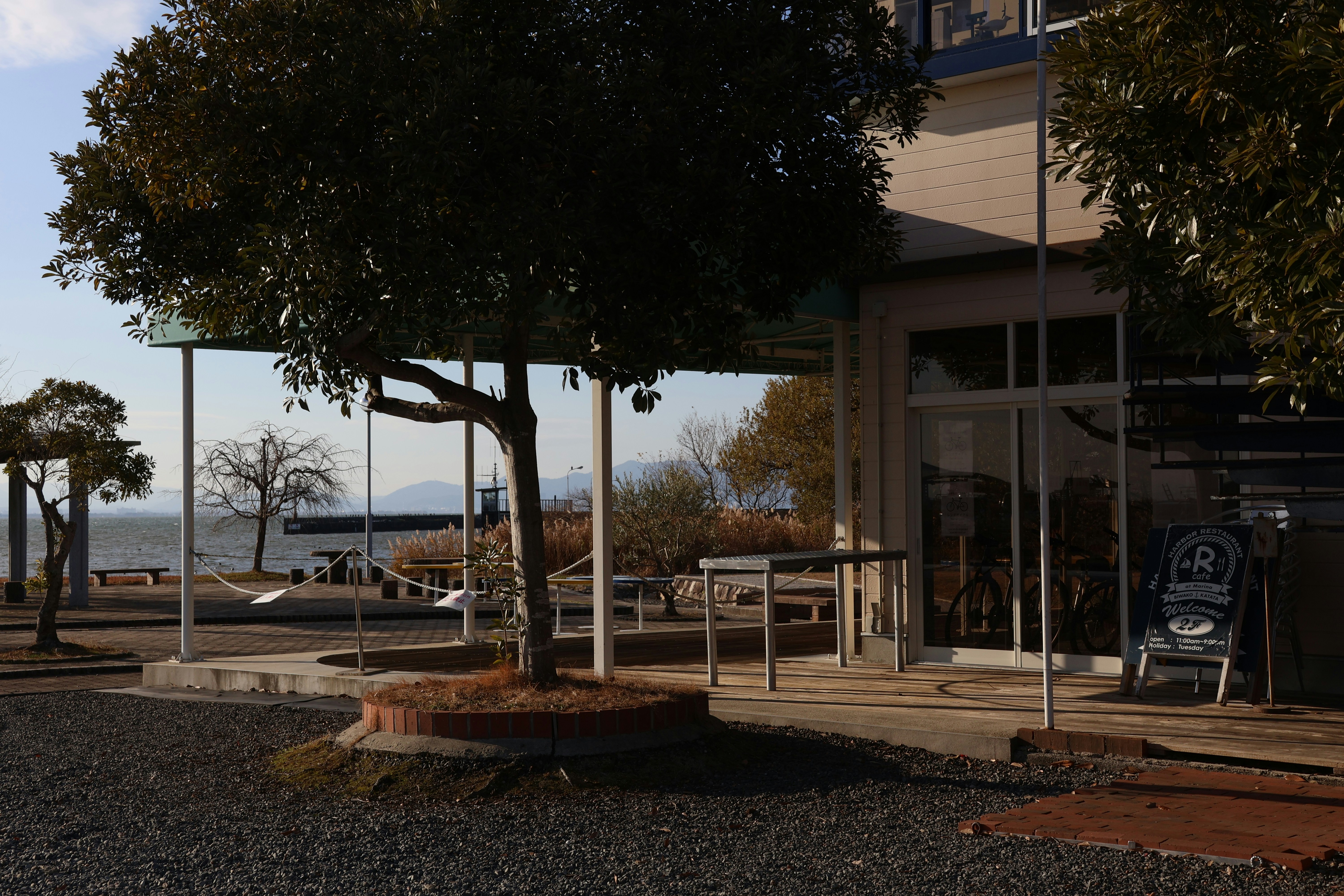 Quiet Boulevard: Sunlit Modern Exterior by the Coastal Café
