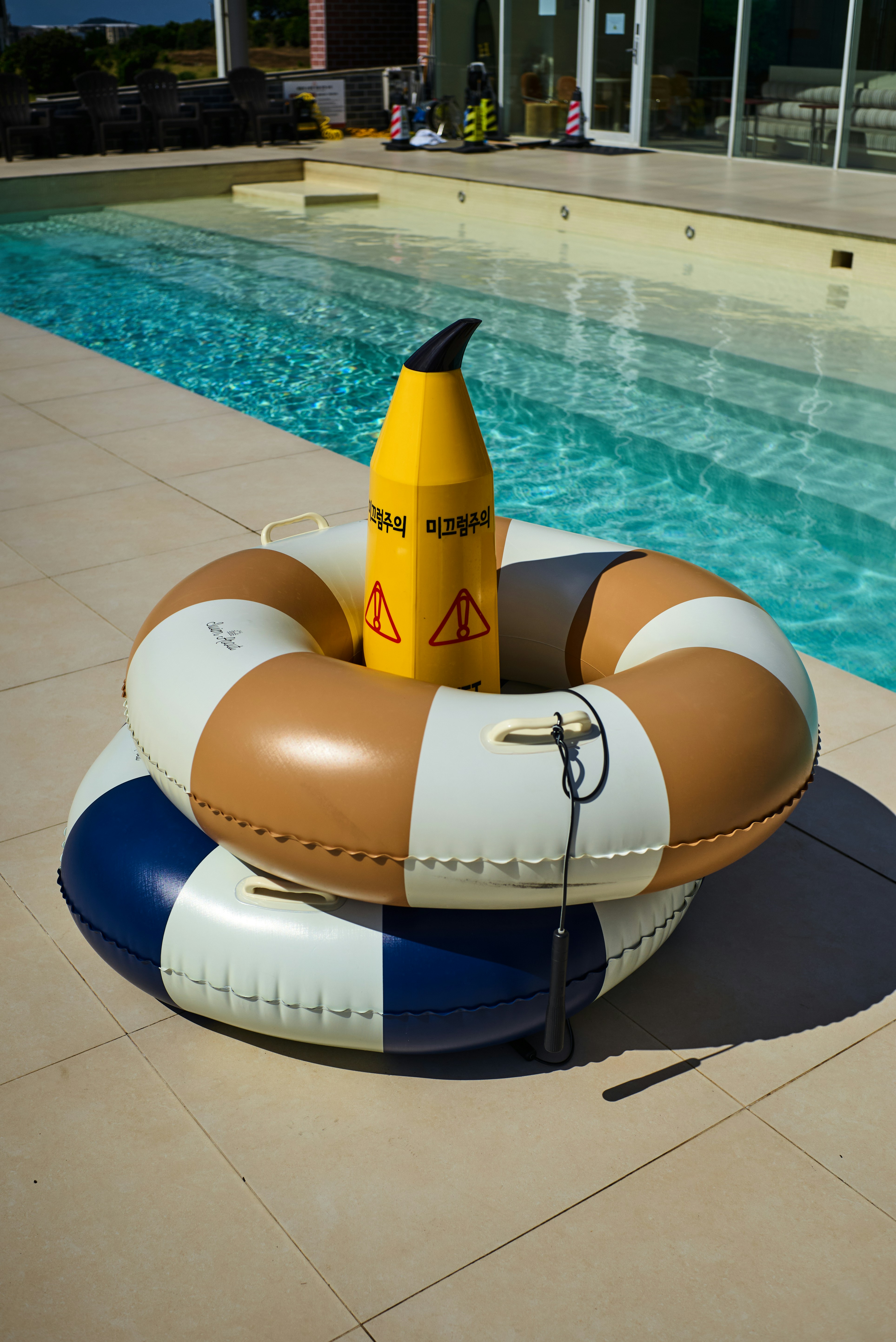 A banana sitting on top of an inflatable raft next to a swimming pool ...