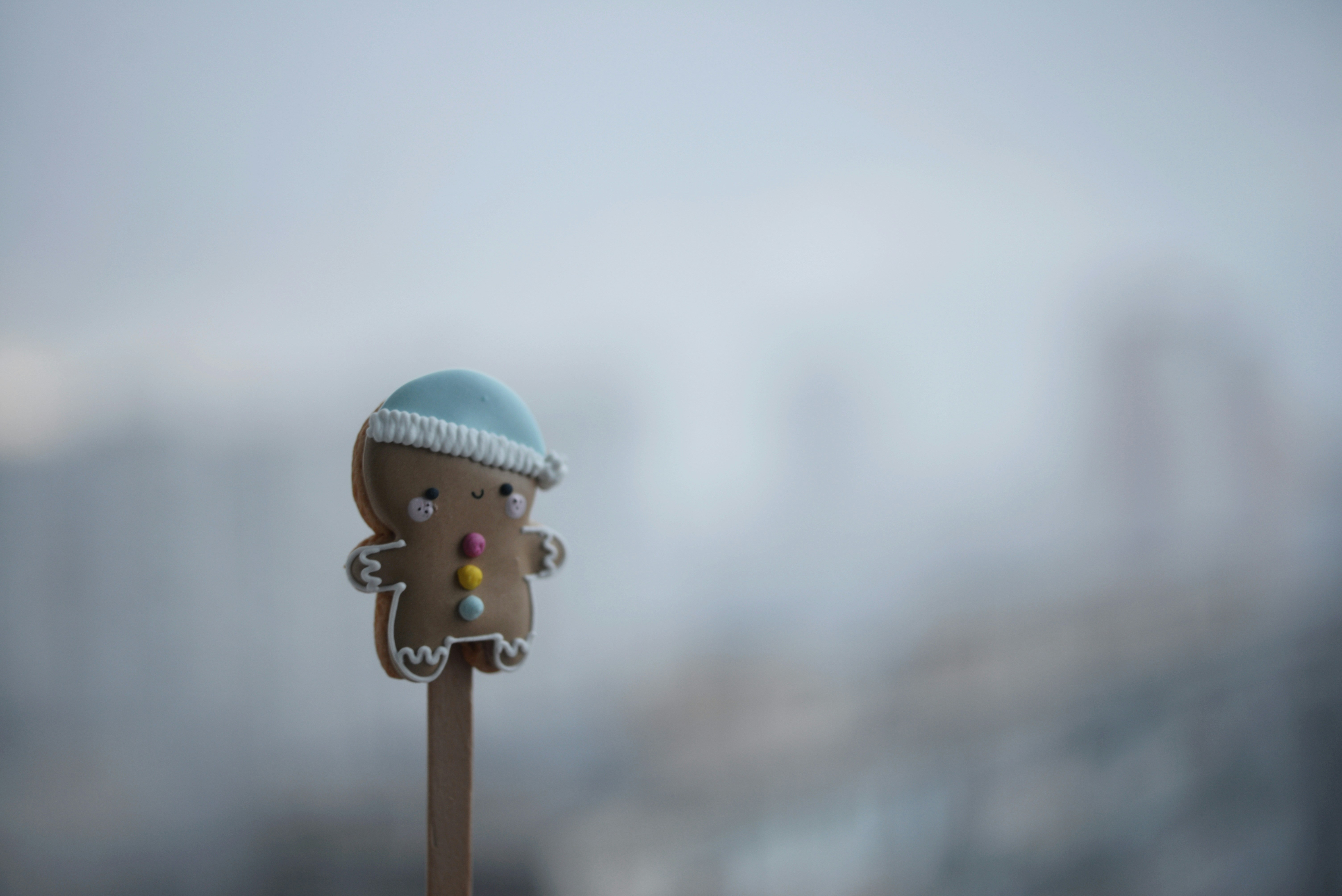 Gingerbread Sentinel on a Stick Before a Misty Cityscape