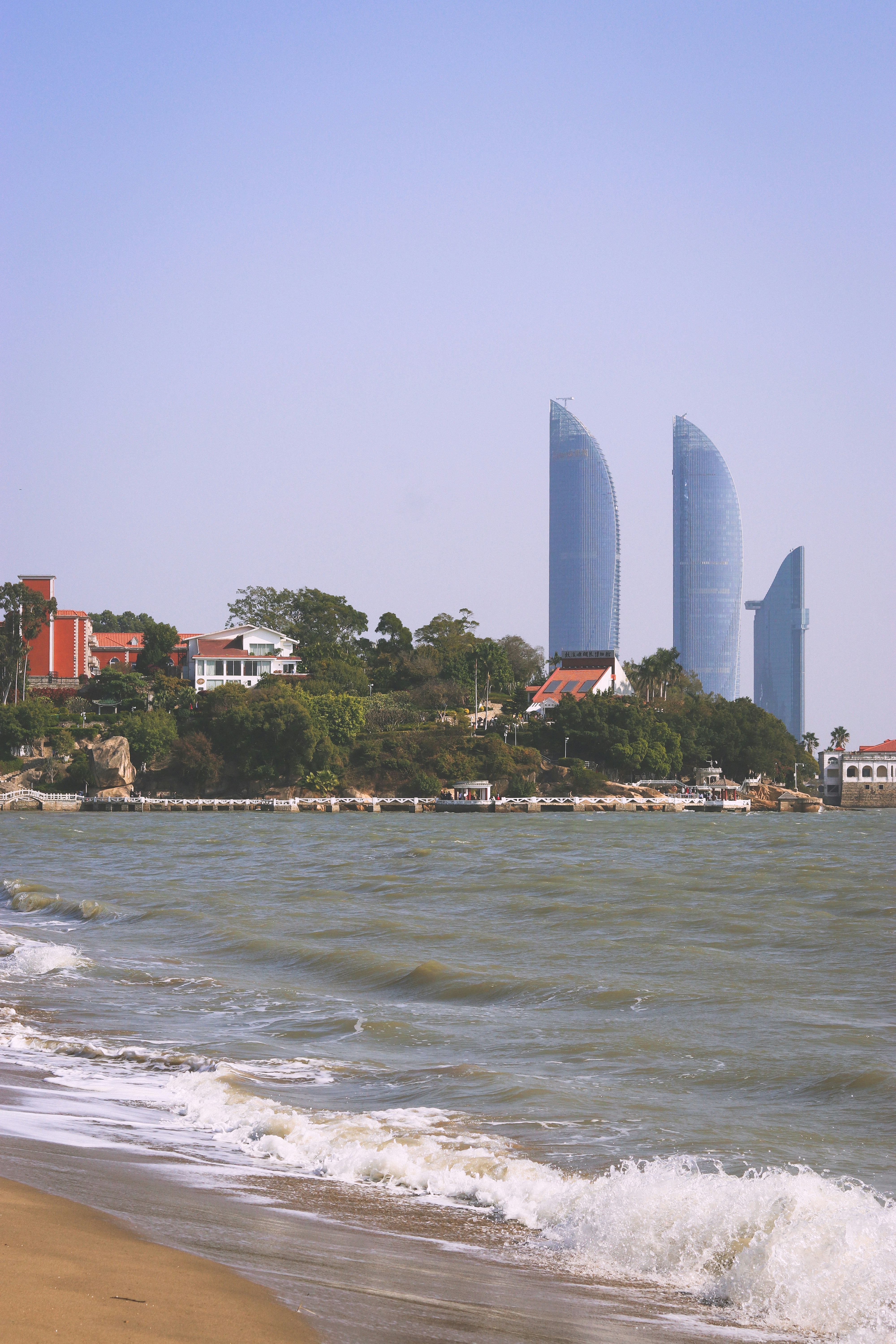Twin Glass Promontory: Distant Towers Rise Over a Quiet Coastal Village