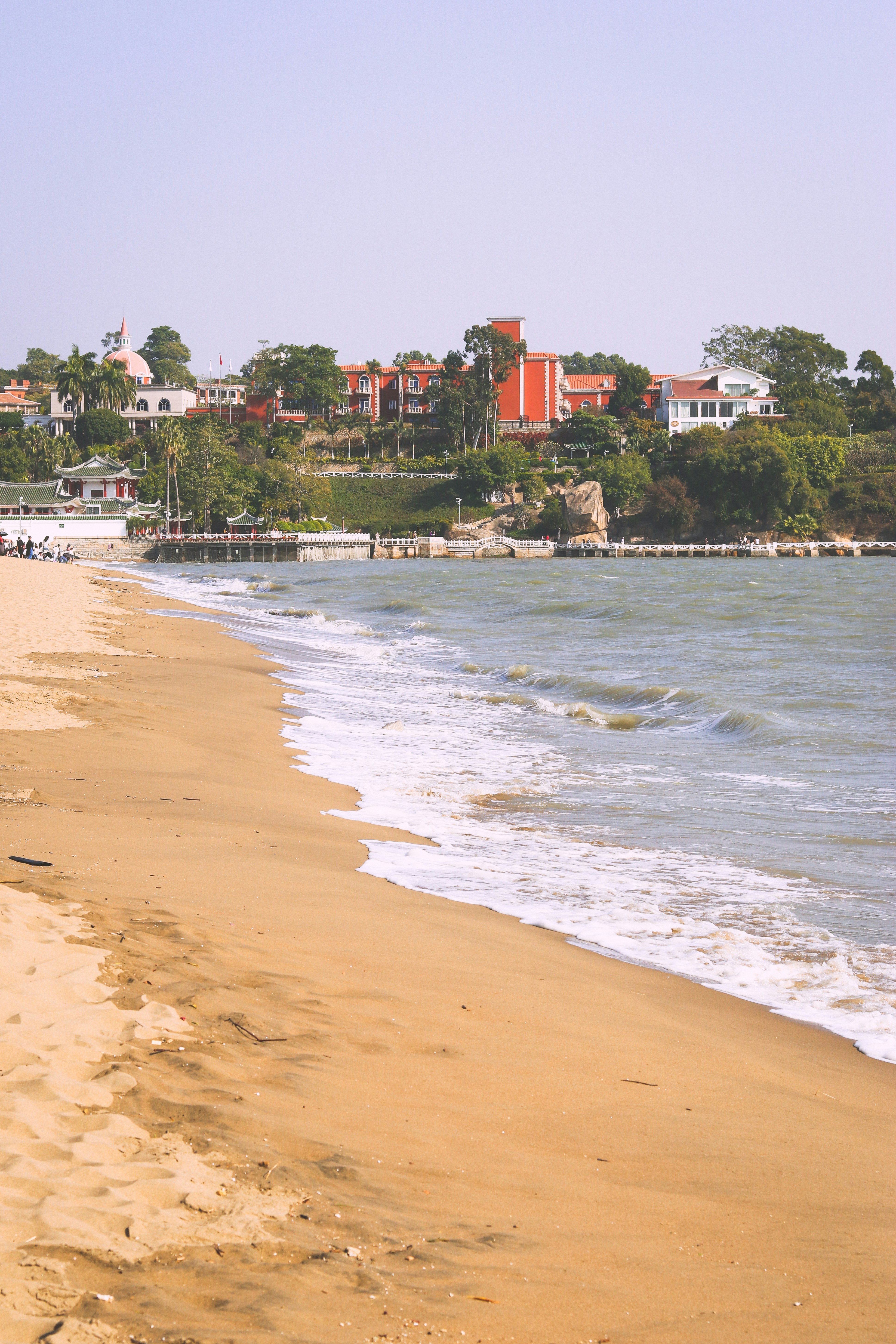 Sunny shoreline with coastal homes on a gentle hill