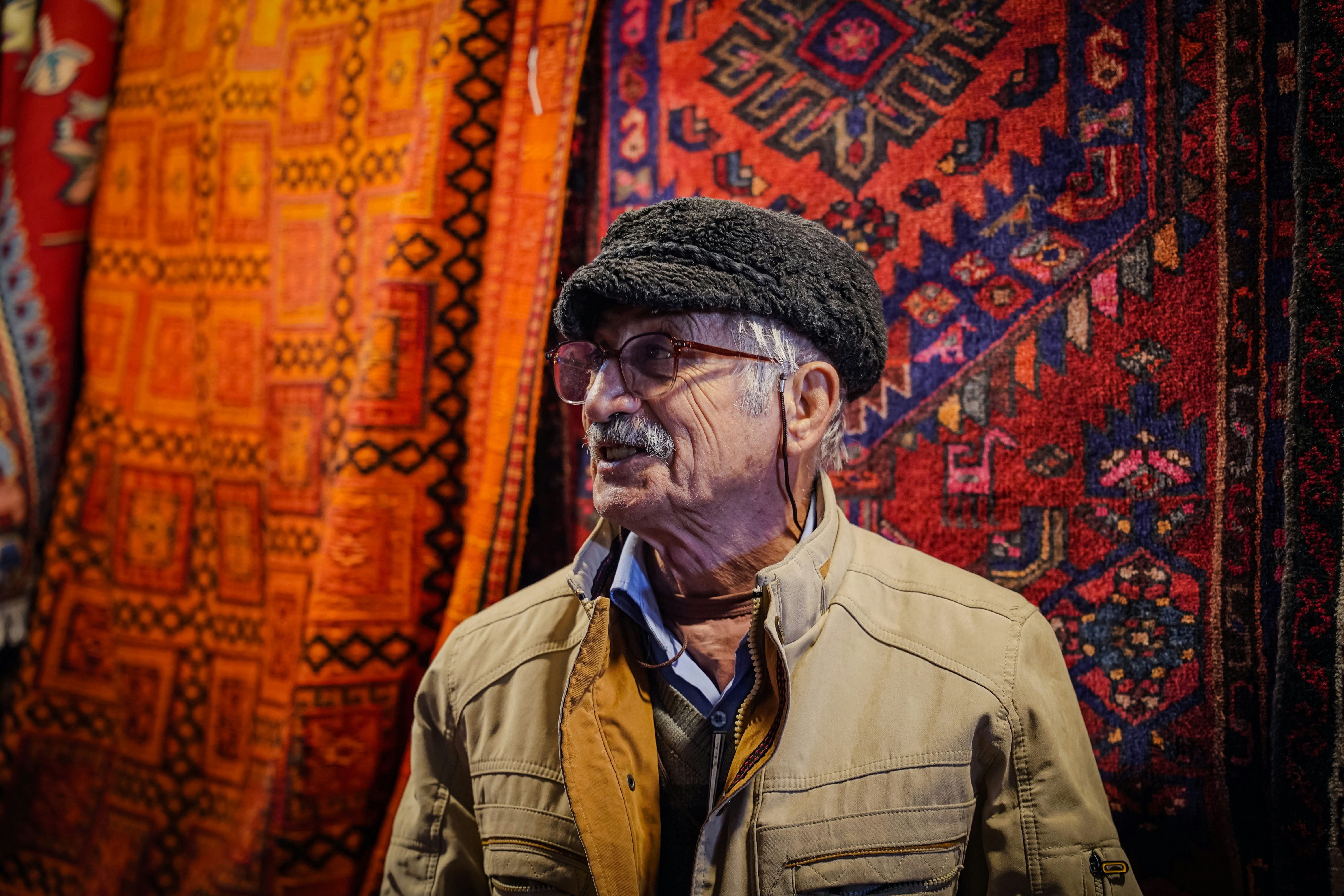 A man standing in front of rugs in a store photo – Free Iran Image on ...