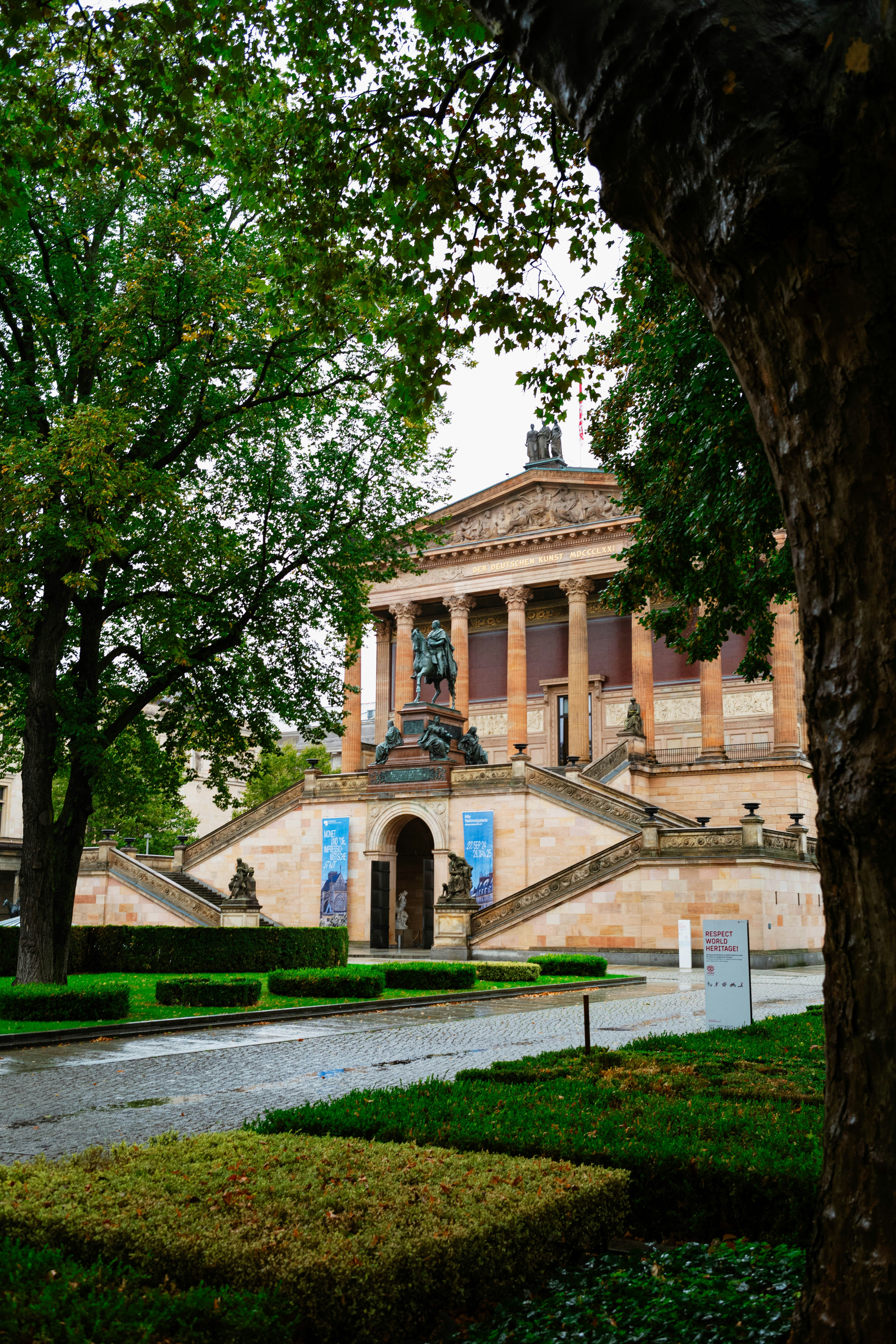 Equestrian Statue Framed by Neoclassical Façade and Verdant Canopy
