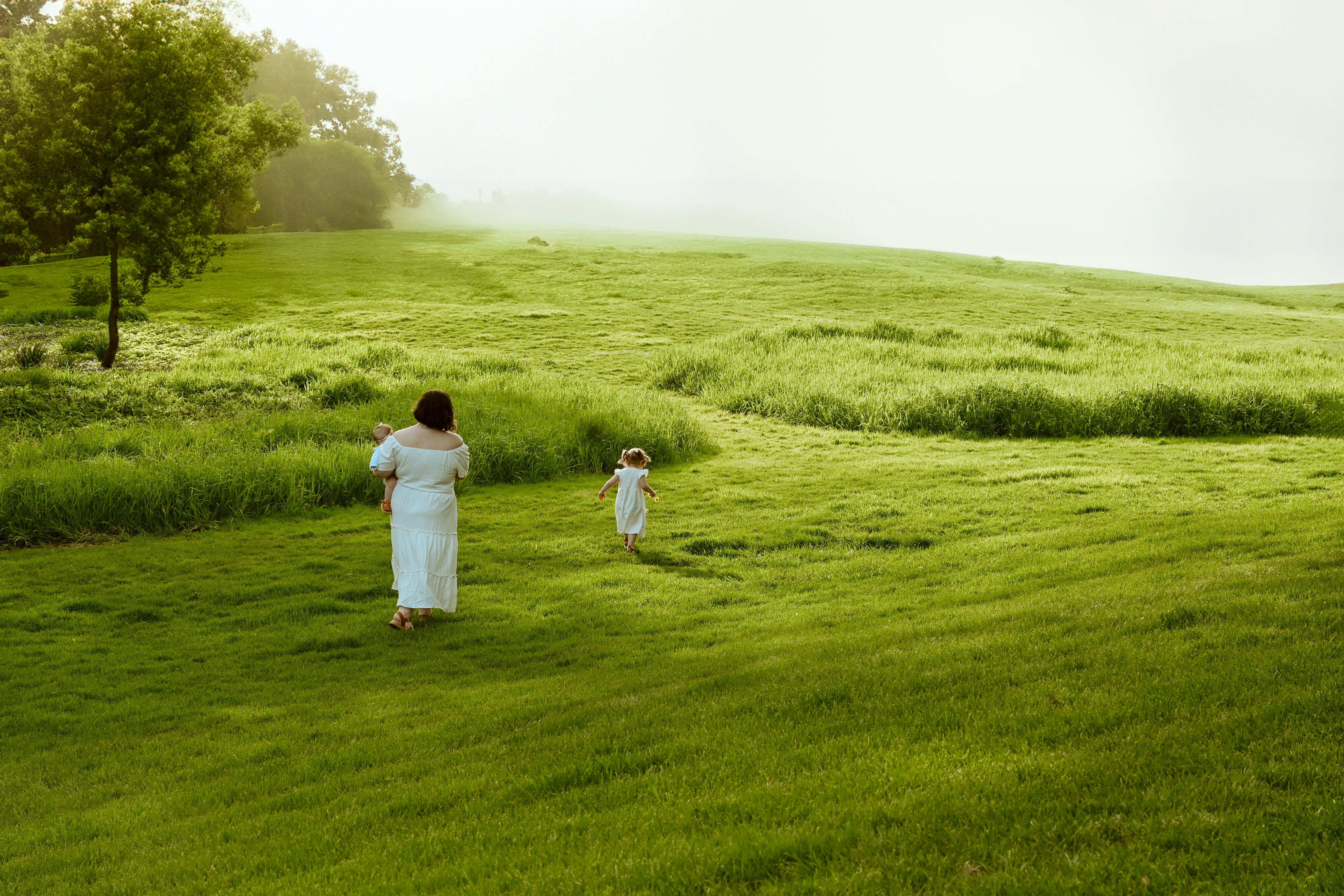 White-Robed Silhouettes Trek Across a Dewy Meadow Toward the Morning Mist