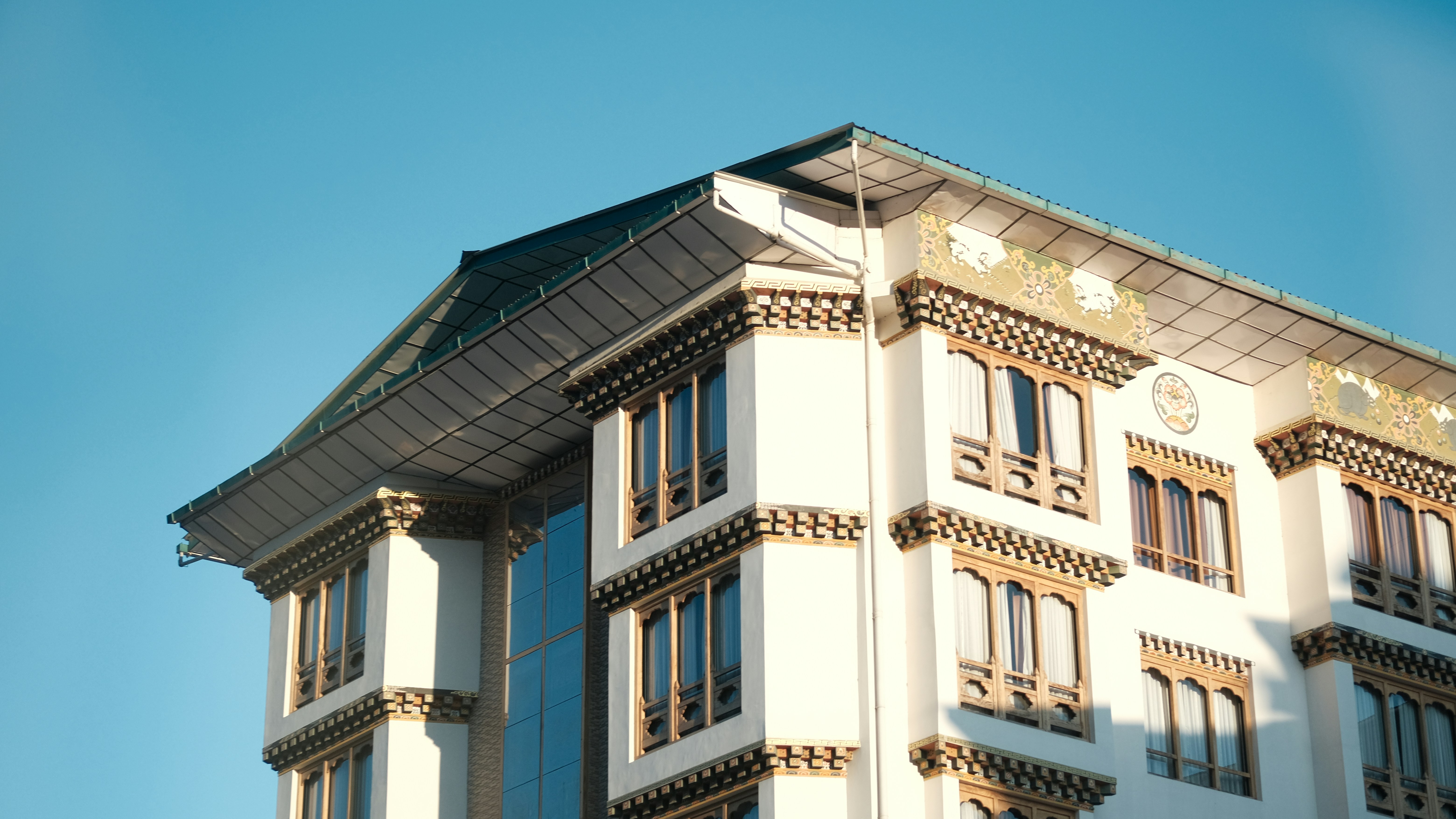 Traditional architectural building facade with intricate wooden details against a clear blue sky.