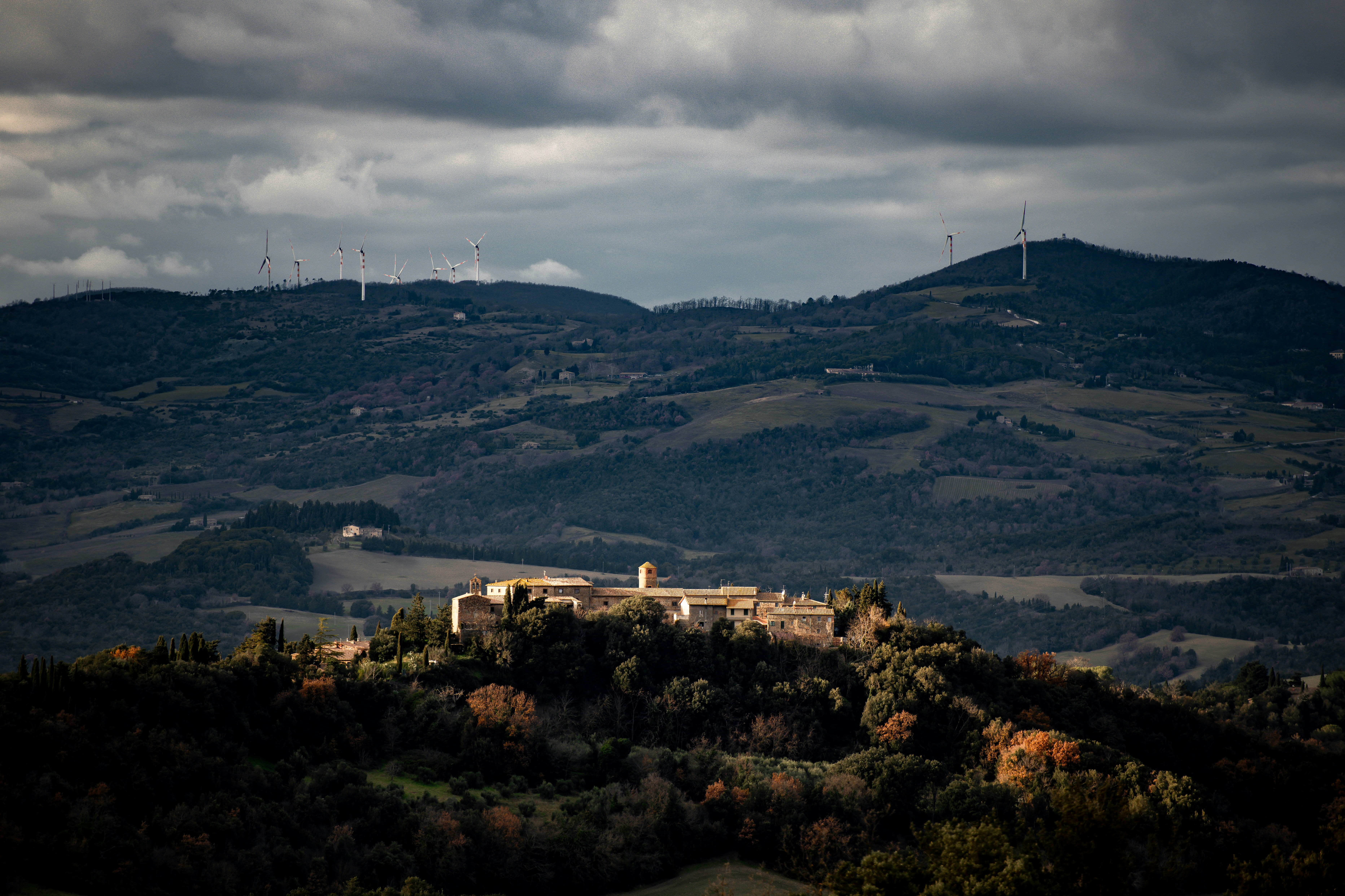 A hill with a house on it under a cloudy sky photo – Free Italy Image ...