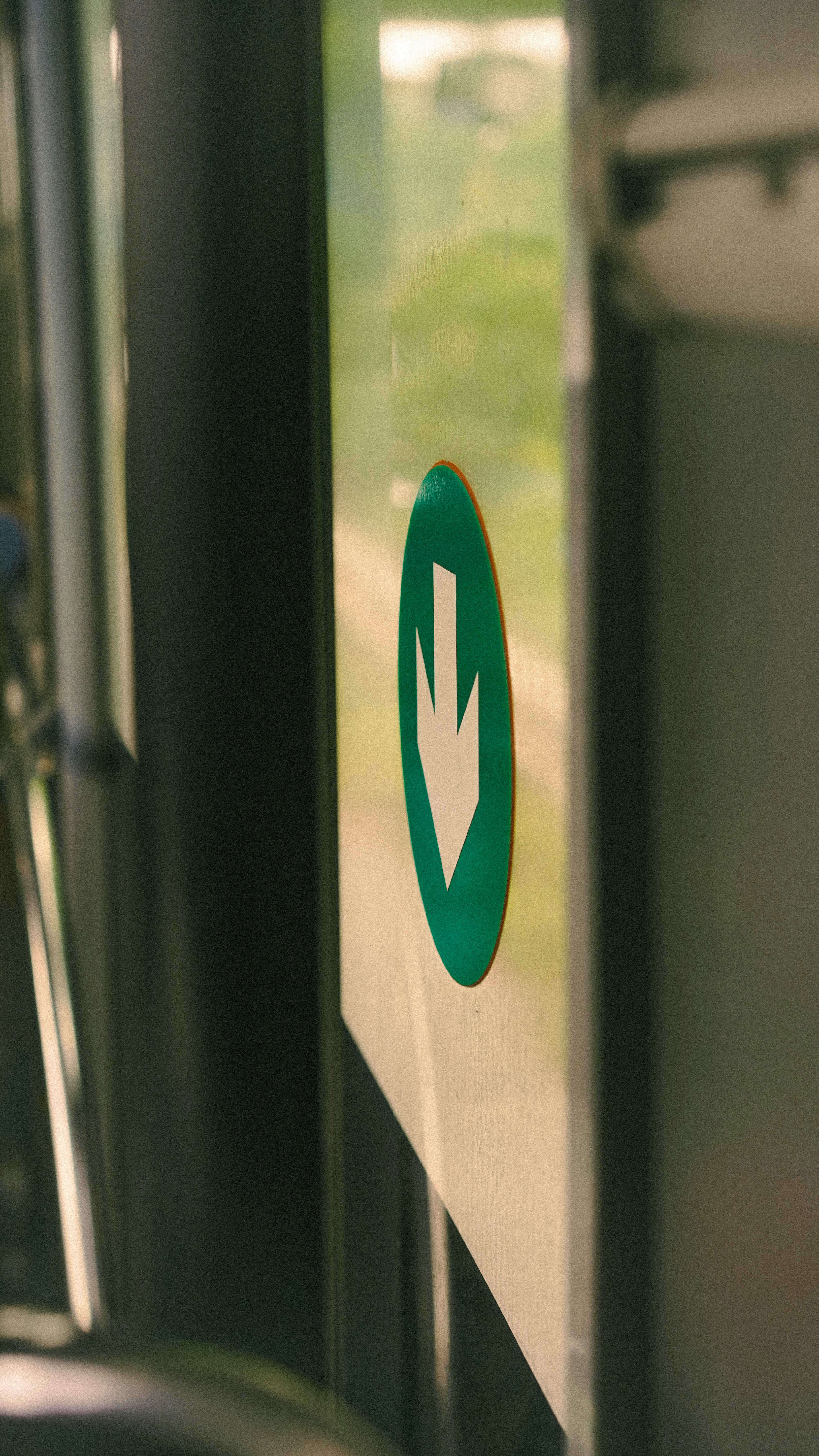 Green Arrow Safety Sign on a Train Door: A Portrait of Depth