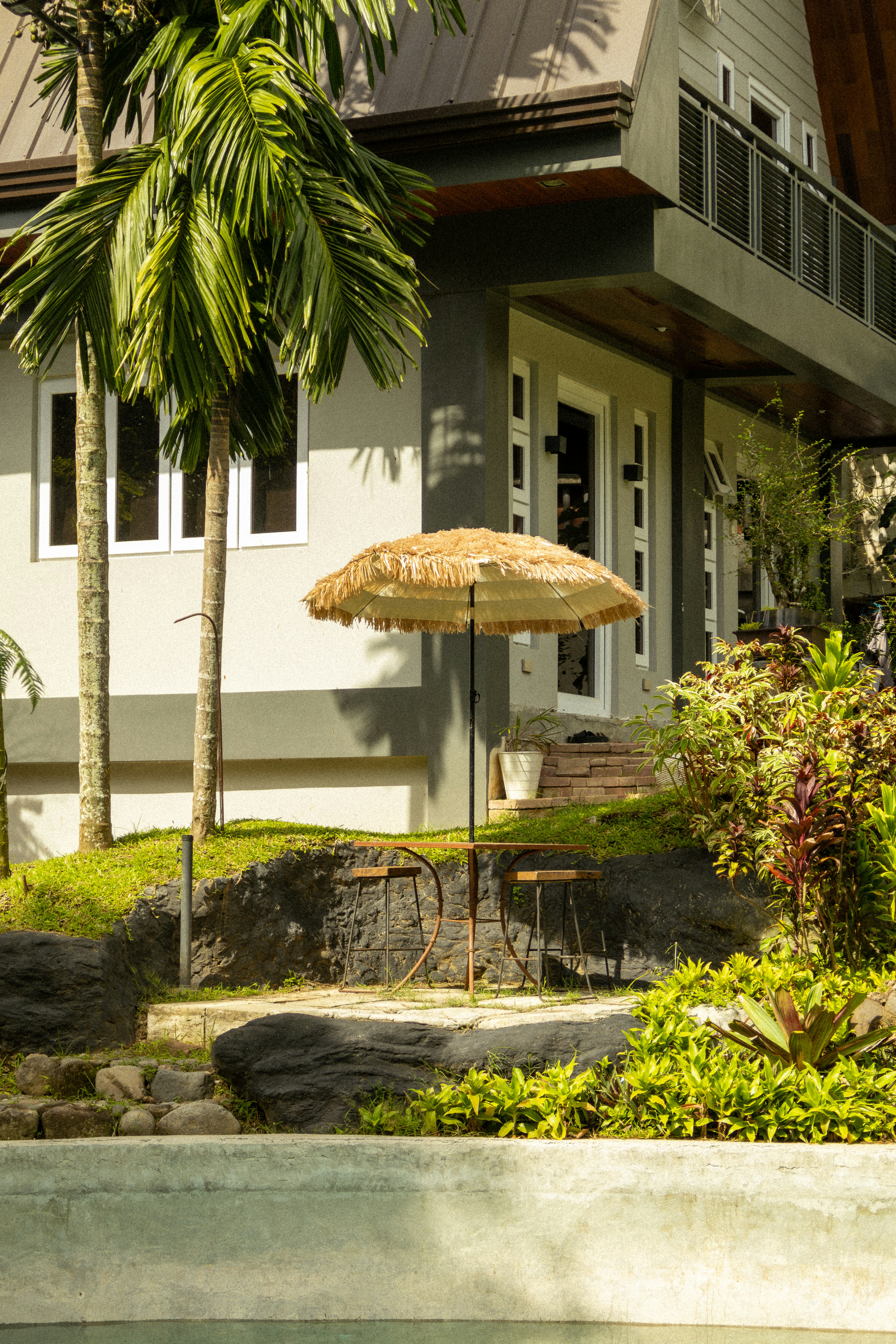 Thatched Shade by Palm-Framed Steps: A Quiet Poolside Terrace