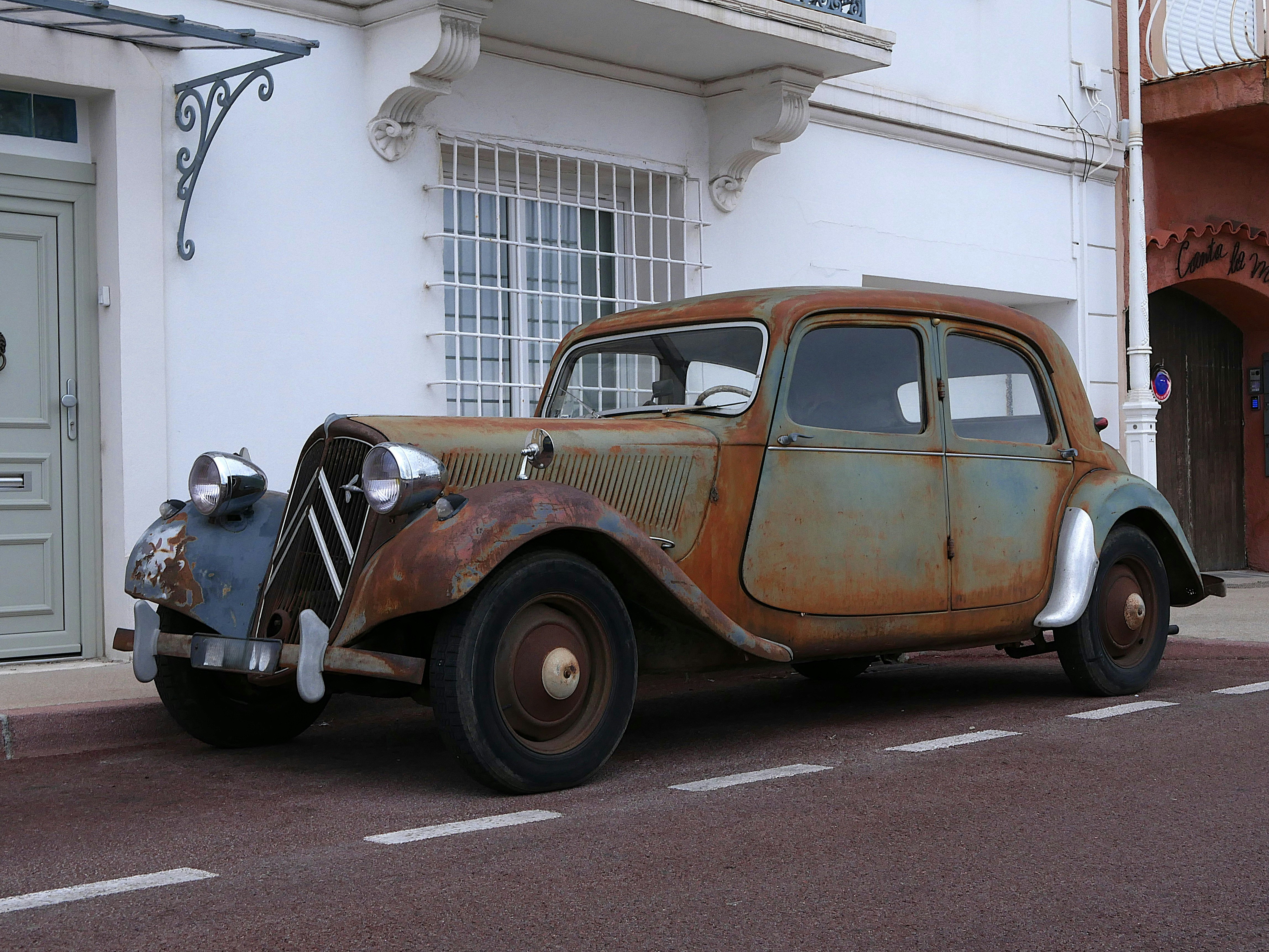 Ein altes, rostiges Auto, das am Straßenrand geparkt ist Foto ...