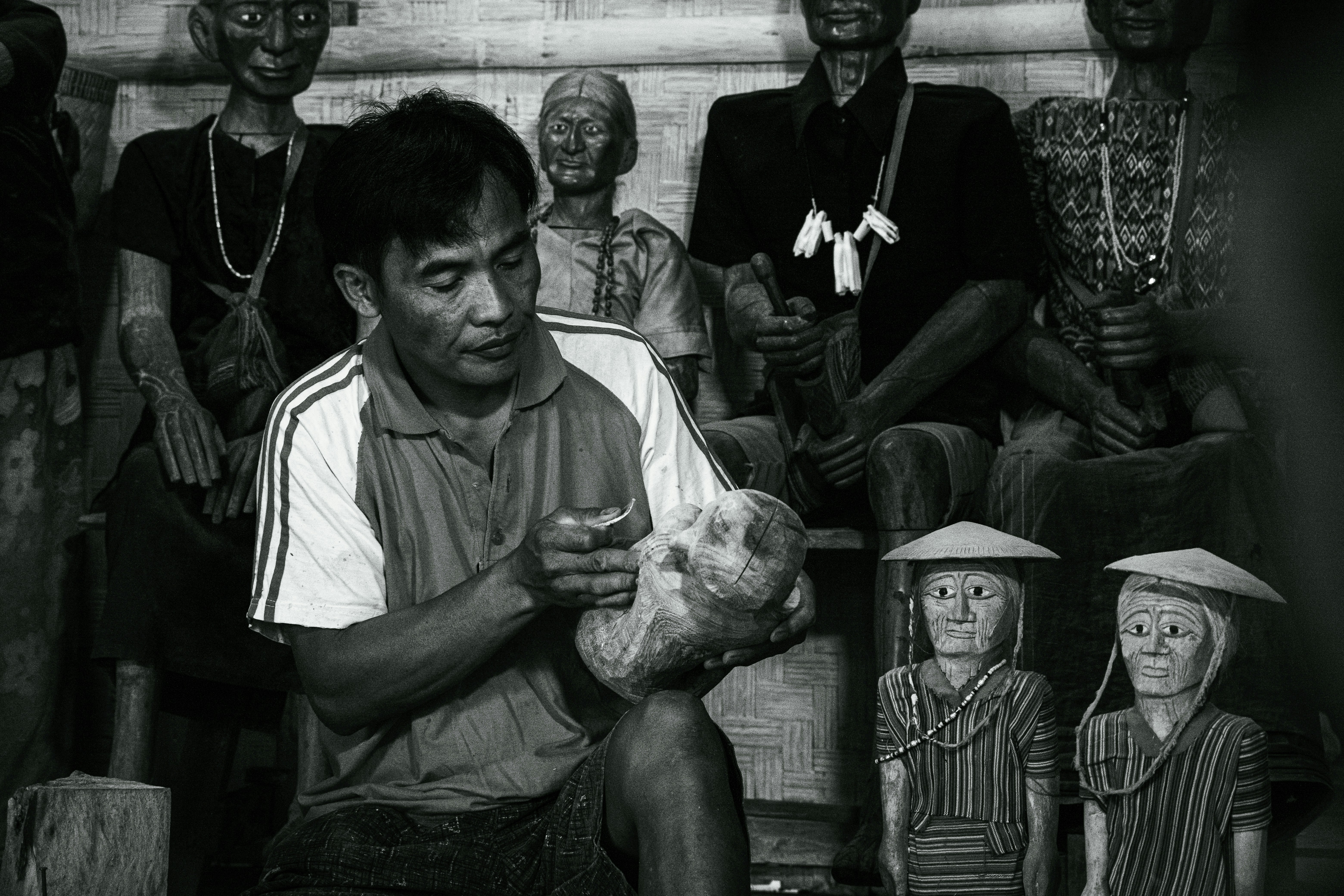 Crafting Memory: A Craftsperson with Figurines in a Dim Workshop