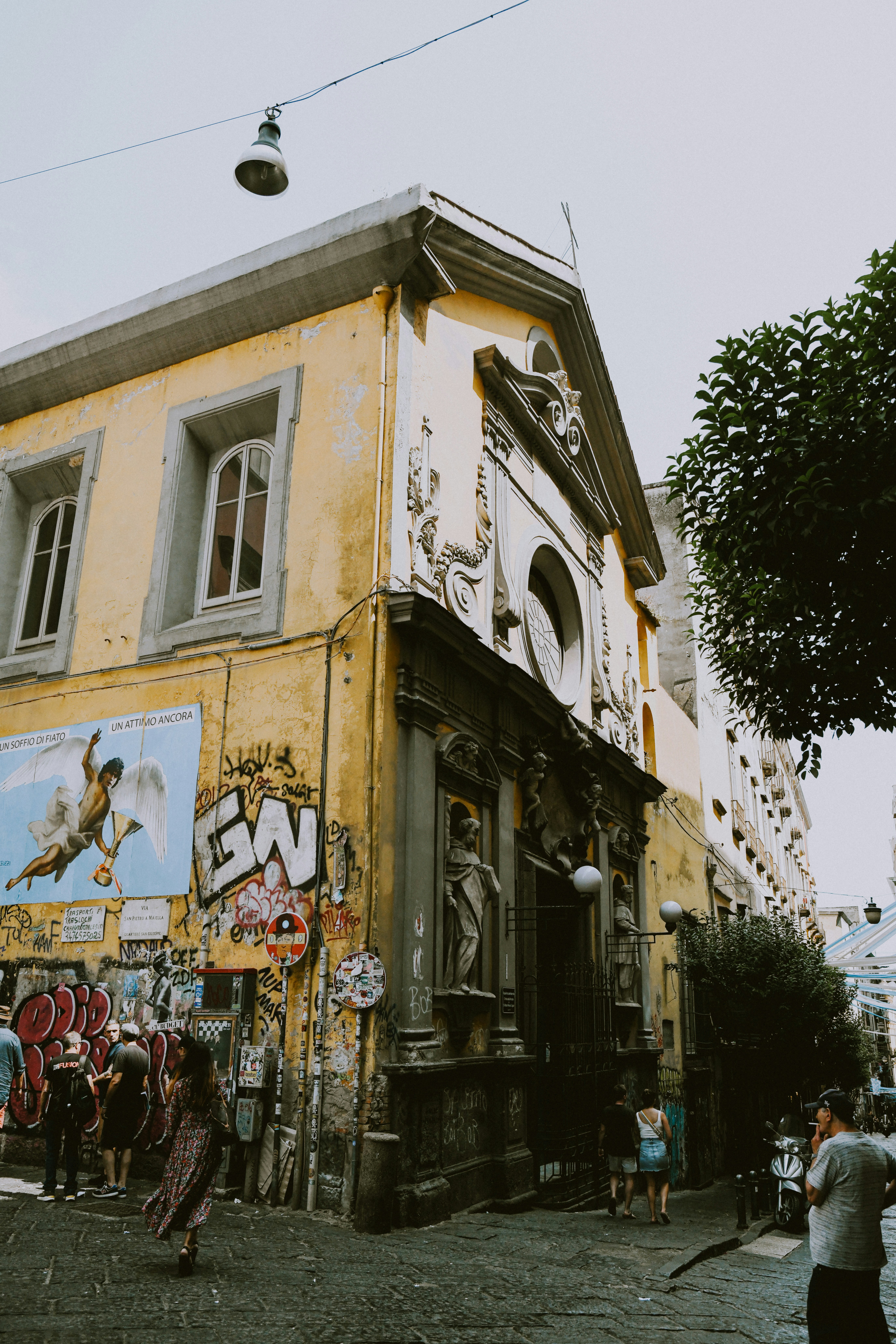 A yellow building with a bunch of graffiti on it photo – Free Napoli ...
