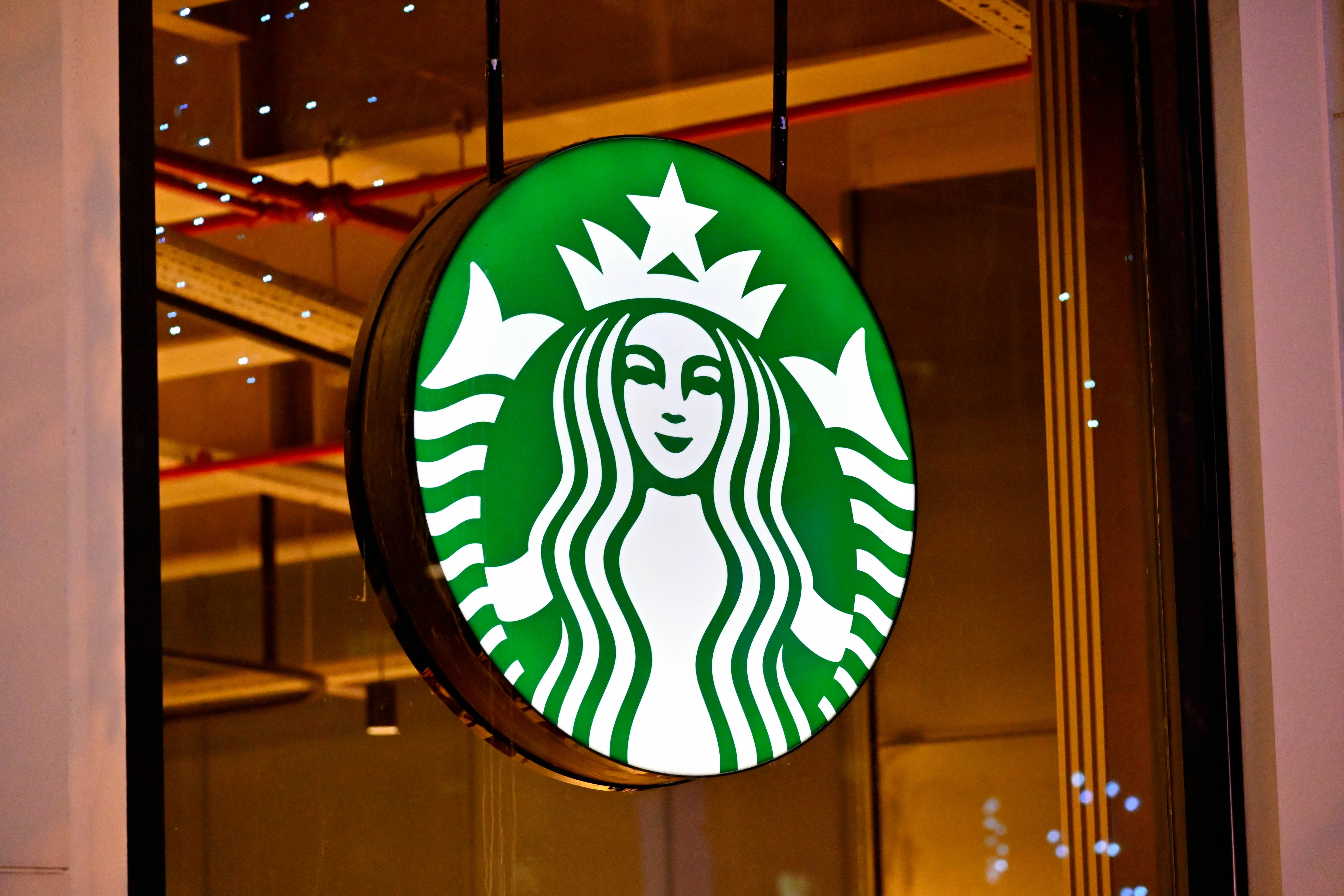 A starbucks sign hanging from the side of a building photo – Free ...