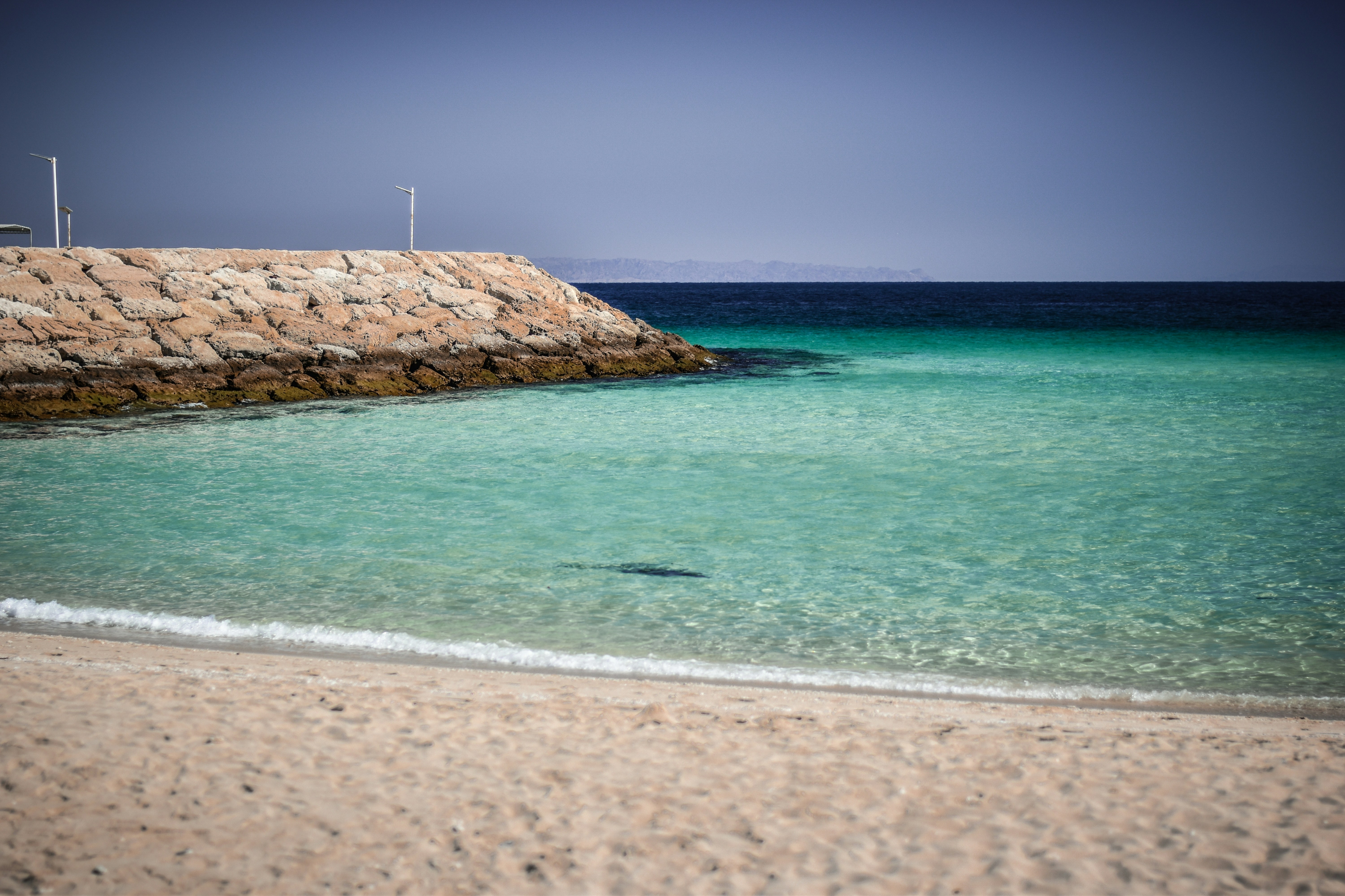 A body of water sitting next to a sandy beach photo – Free Kish island ...