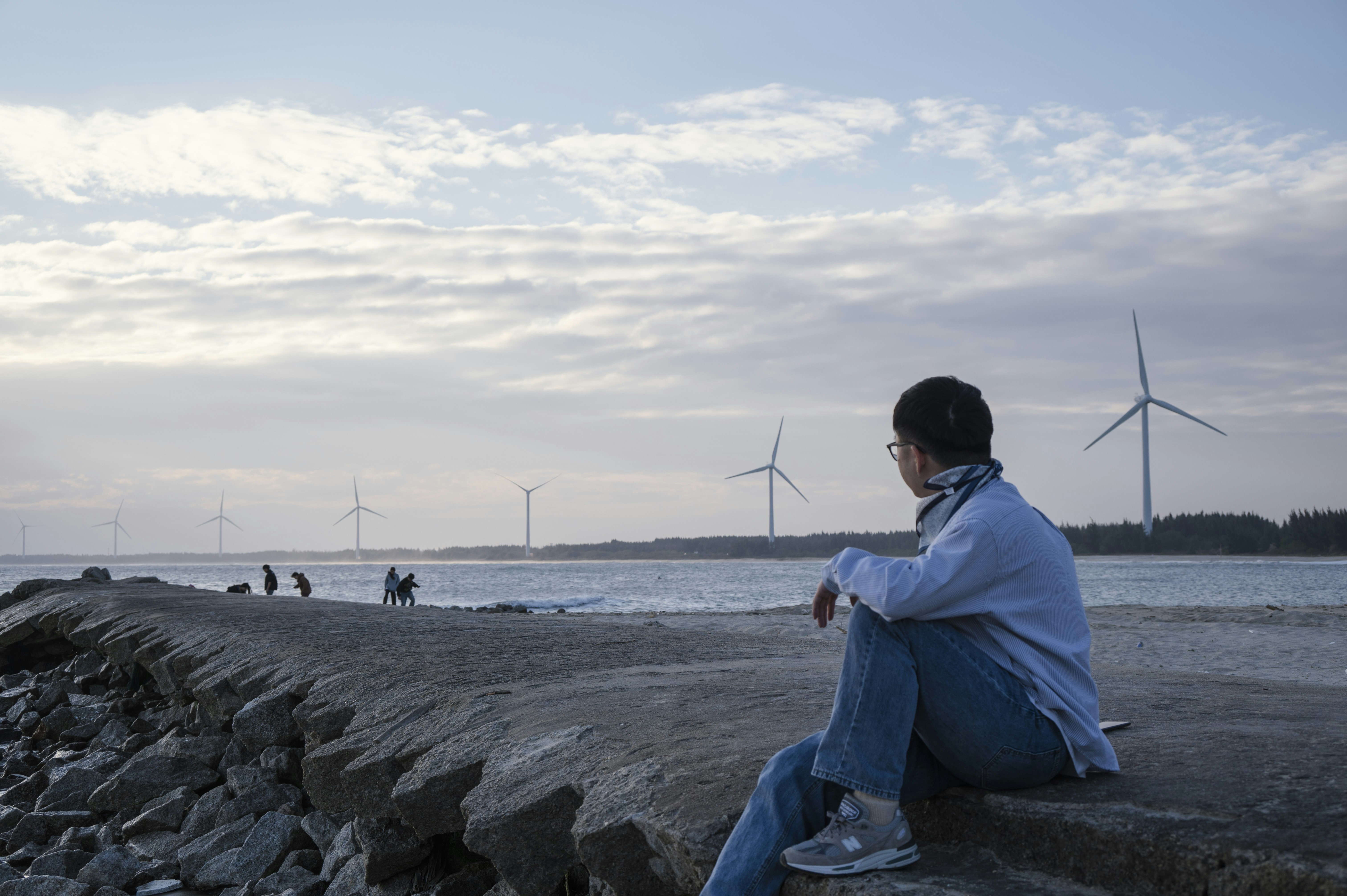 A person sitting on a rock near a body of water photo – Free 汕尾陆丰湖东观海亭 ...
