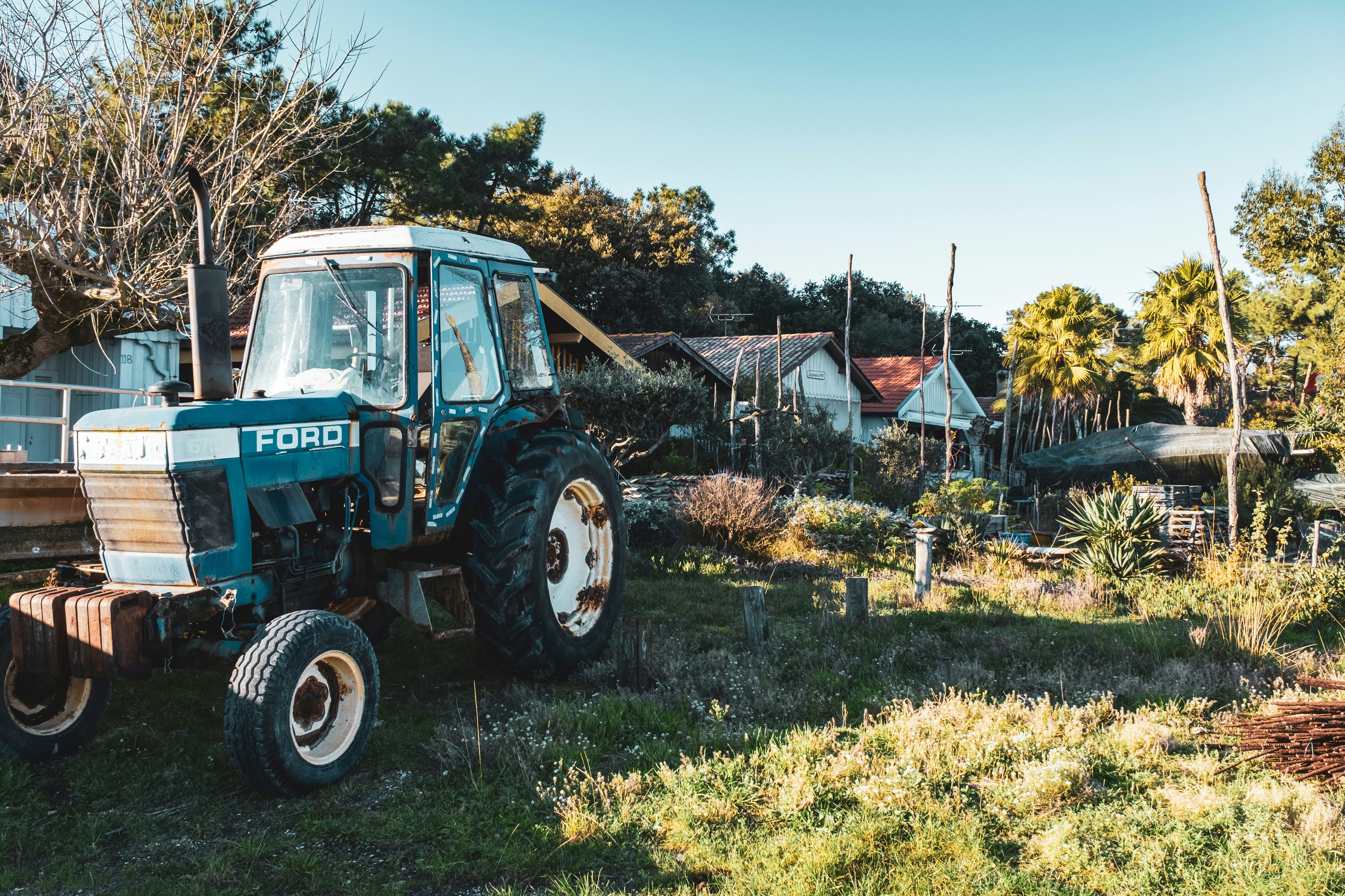 Un tractor estacionado en un campo junto a una casa foto – Imagen de ...