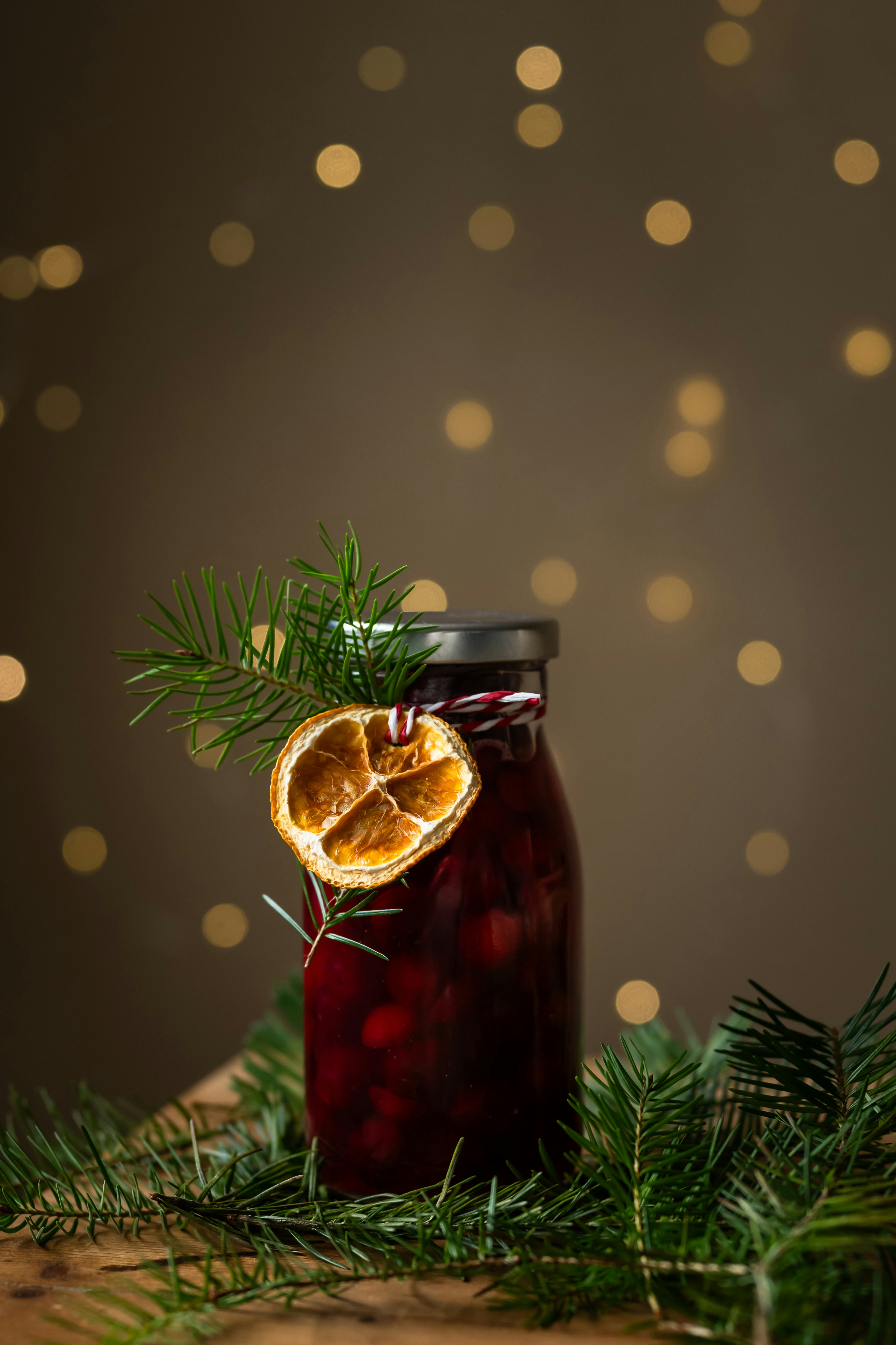 Cranberry Elixir Beneath Pine and Golden Bokeh