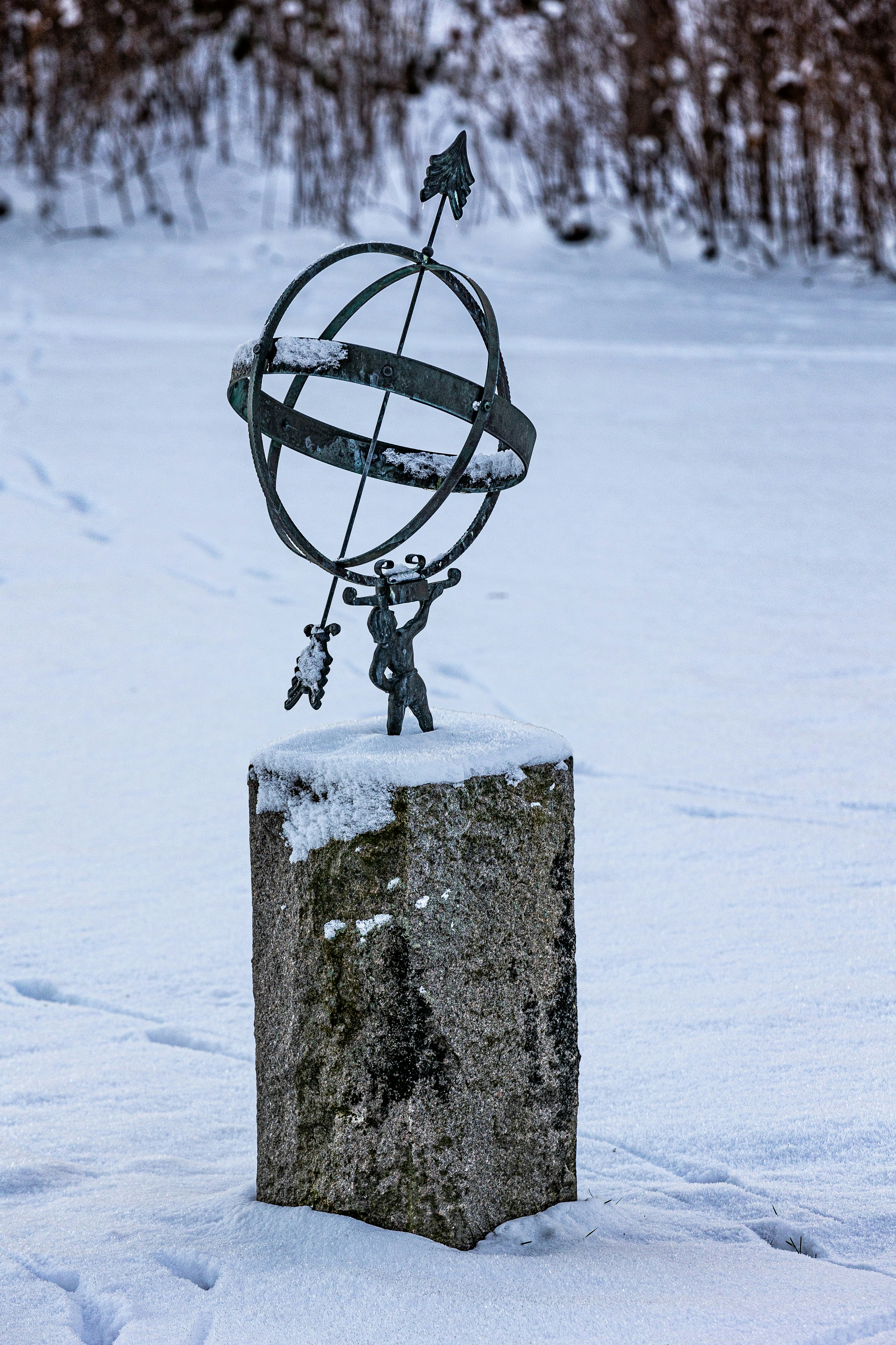 A sun-dial covered in snow literally frozen in time, since it doesn't tell time without sunlight.