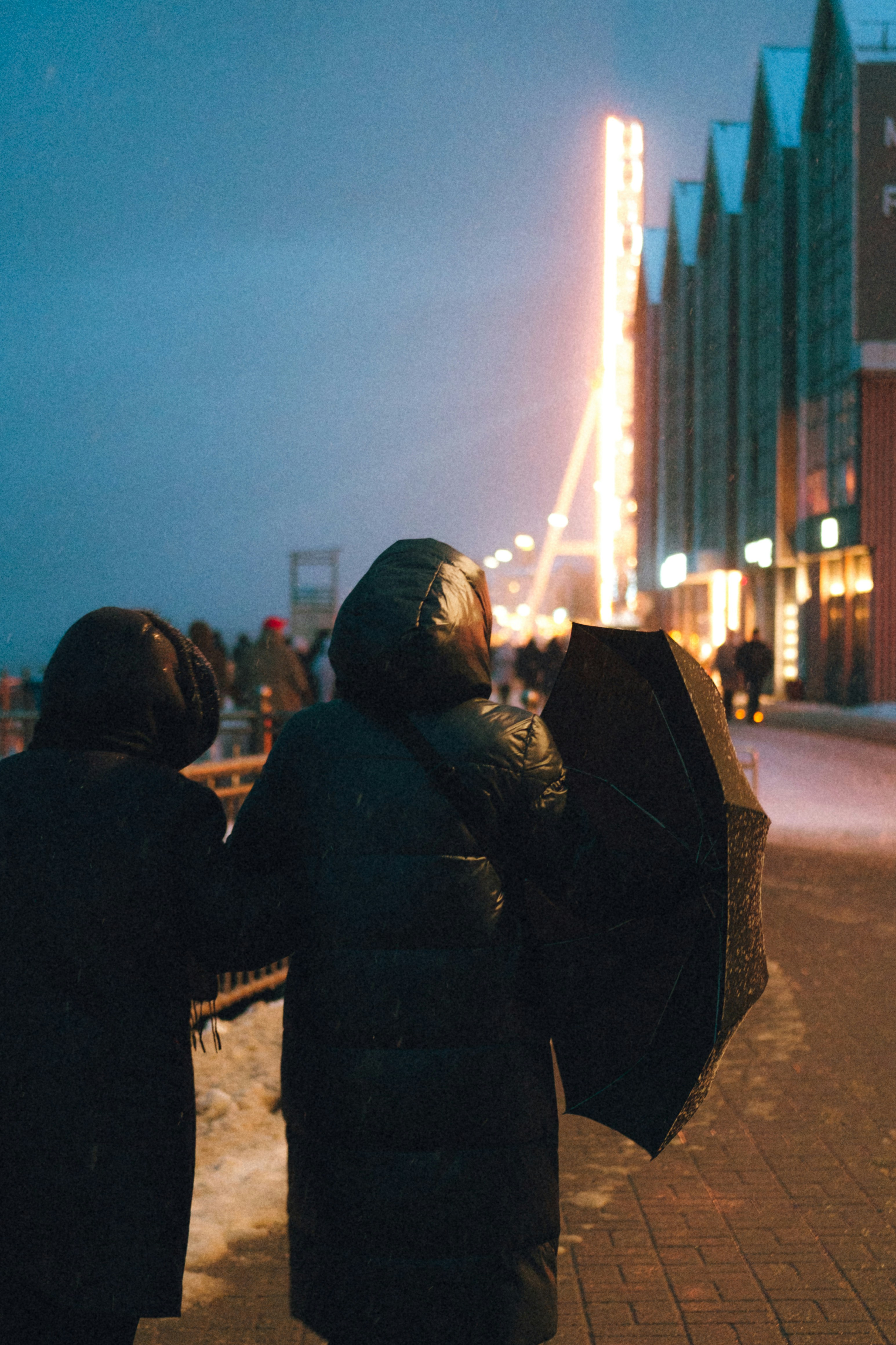 Neon Signage and Winter Stroll Along a Snow-Dusted Promenade
