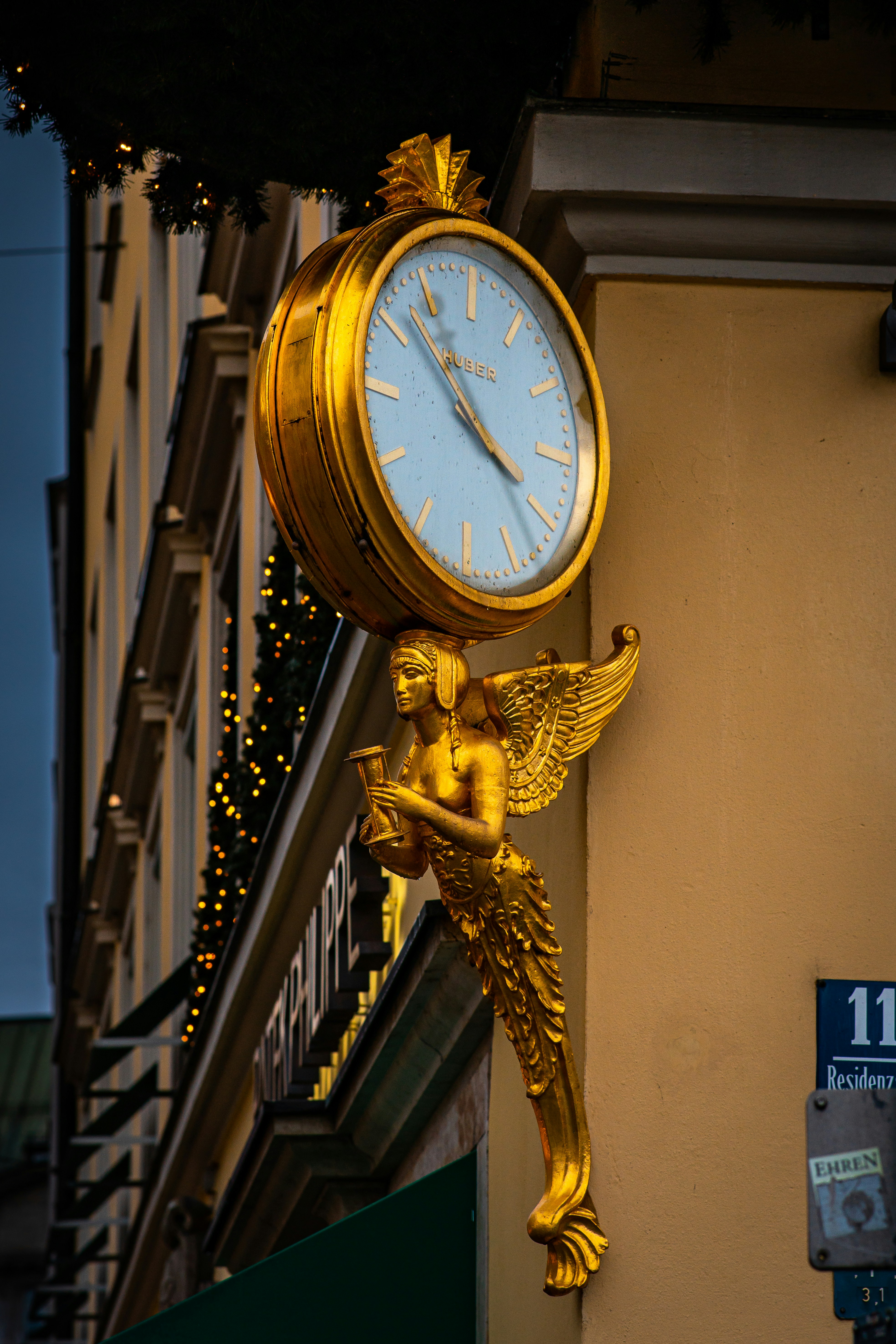 A gold angel clock on the side of a building photo – Free Wallpaper ...