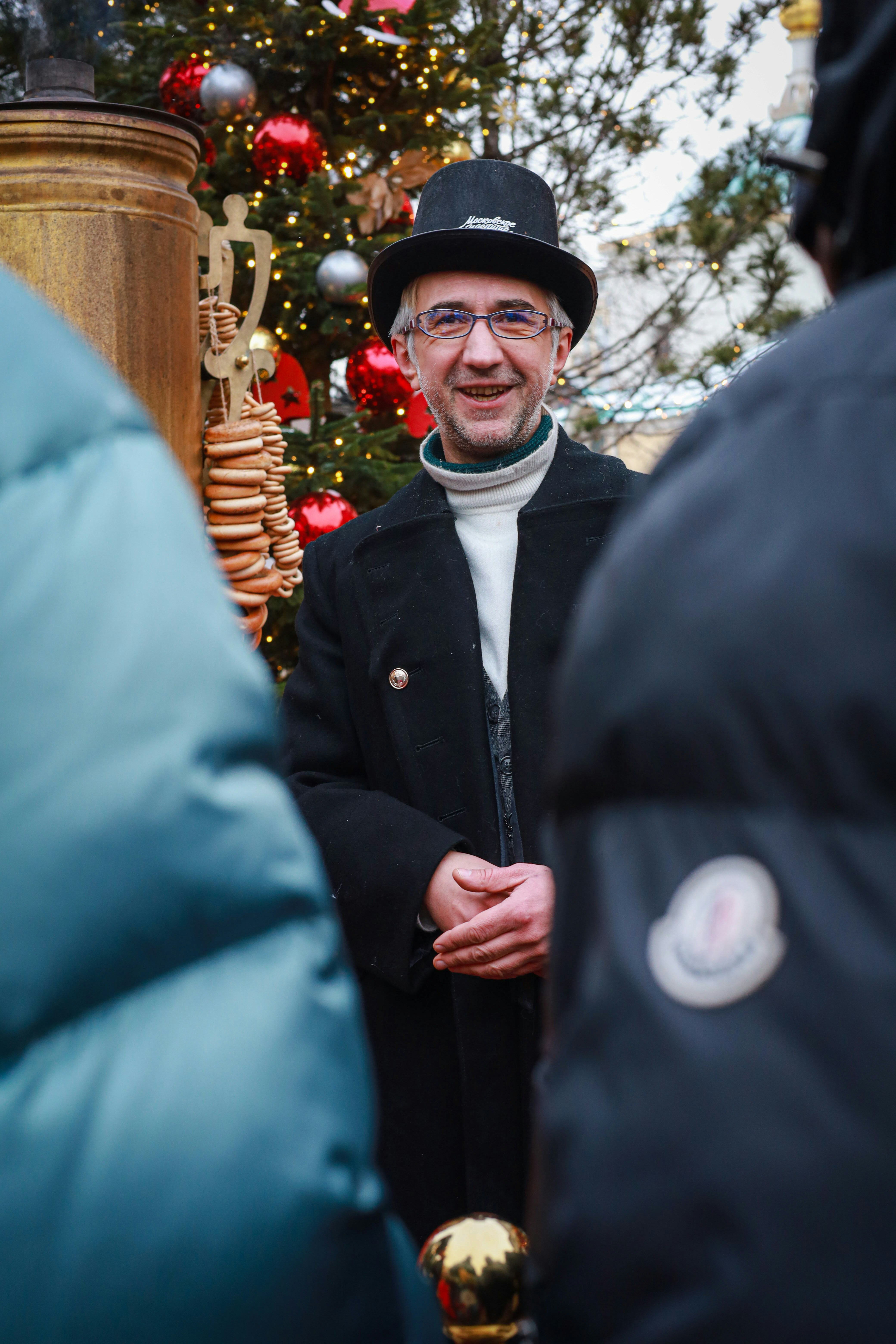 Top Hat Amid Festive Glow: A Candid Christmas Market Portrait