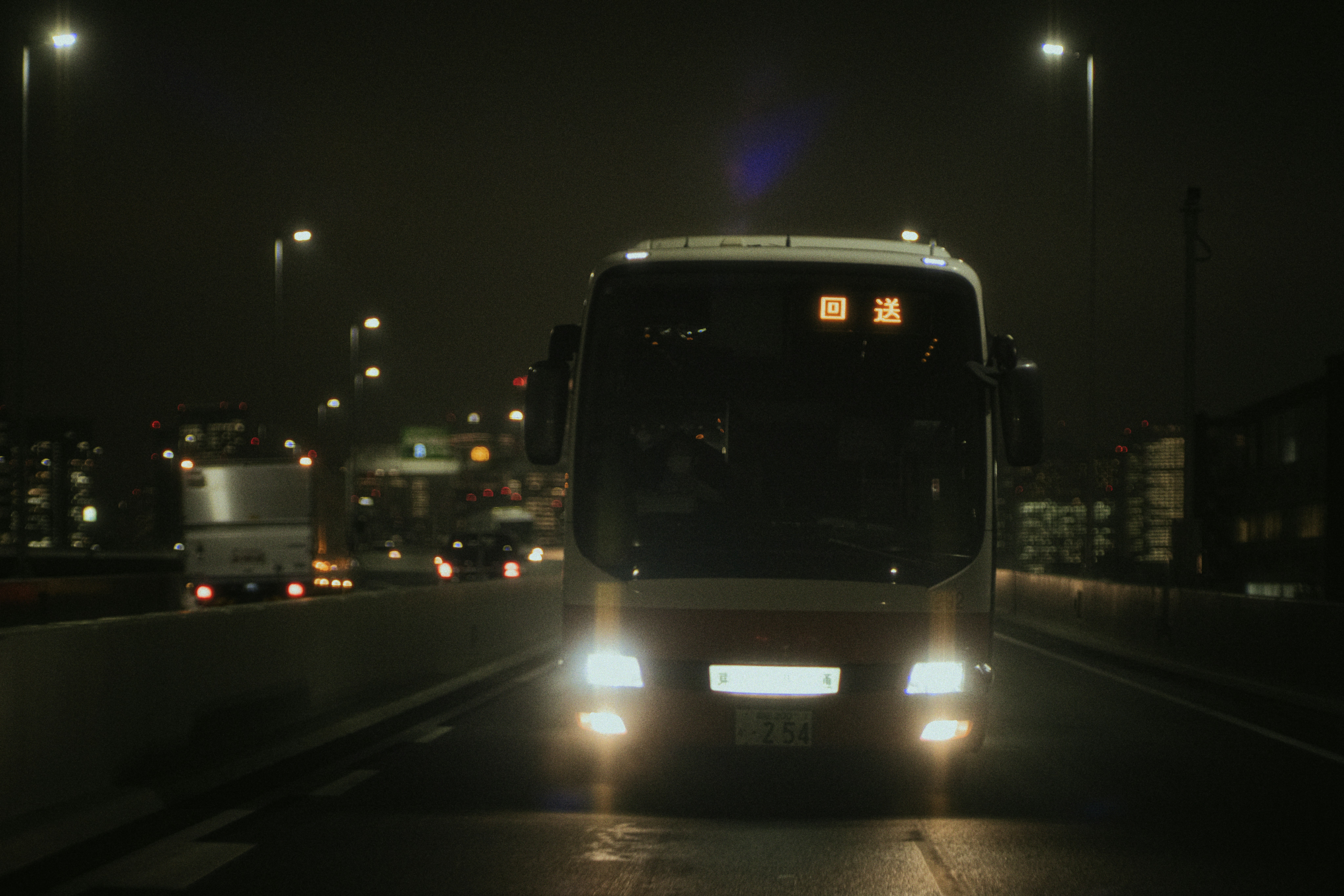 Midnight Approach: A City Bus Looms Forward on a Dimly Lit Highway